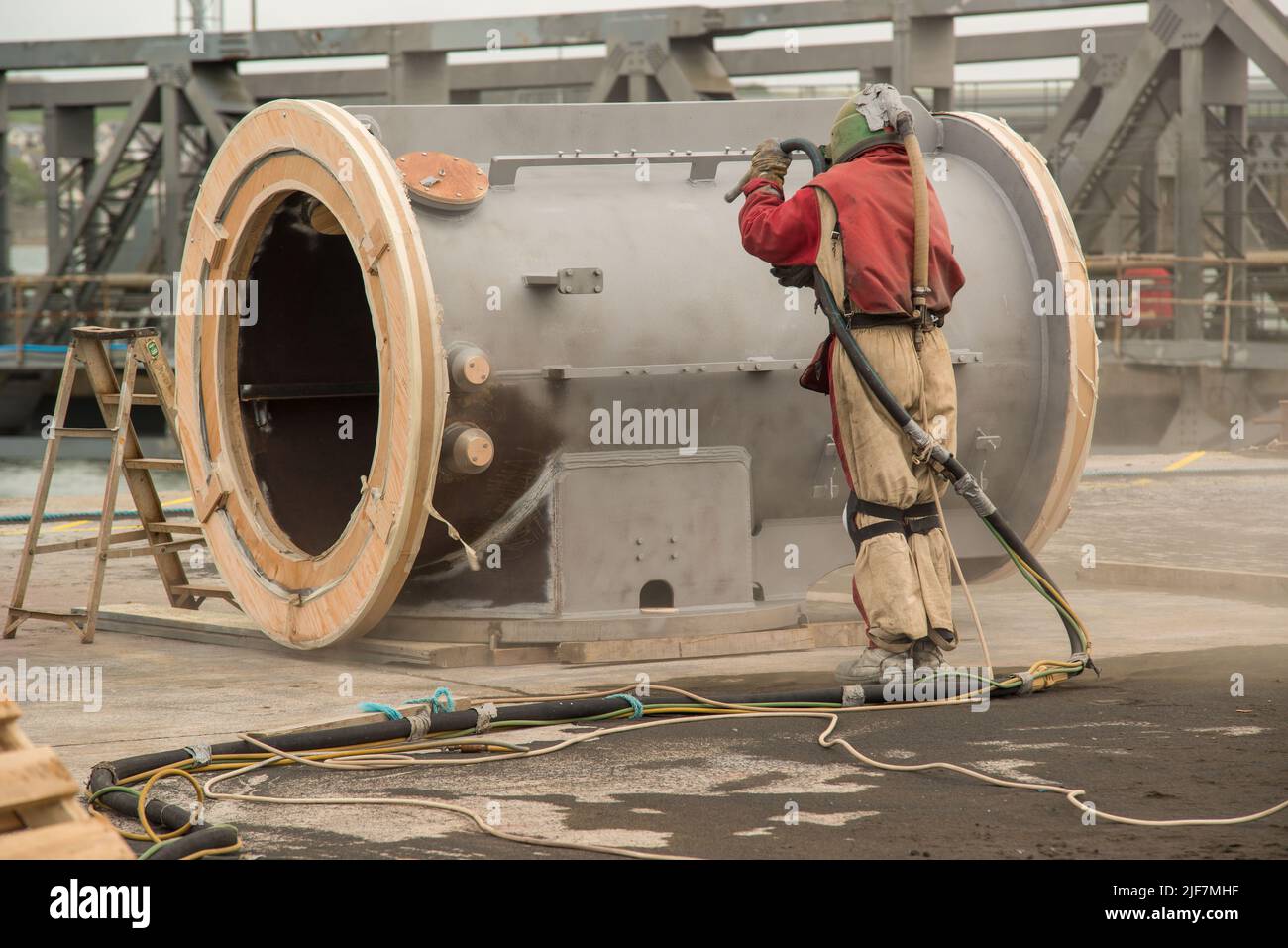 Worker shot blasting component during fabrication of tidal energy ...