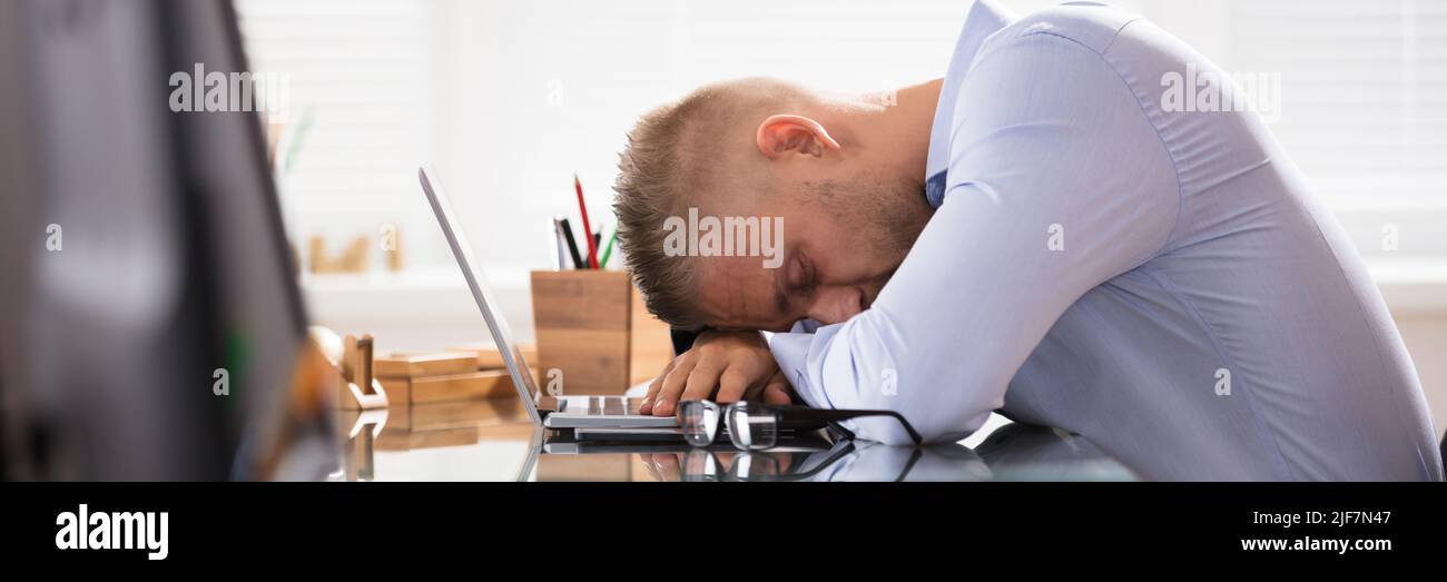 Close-up Of A Businessman Sleeping Over The Office Desk With Laptop ...