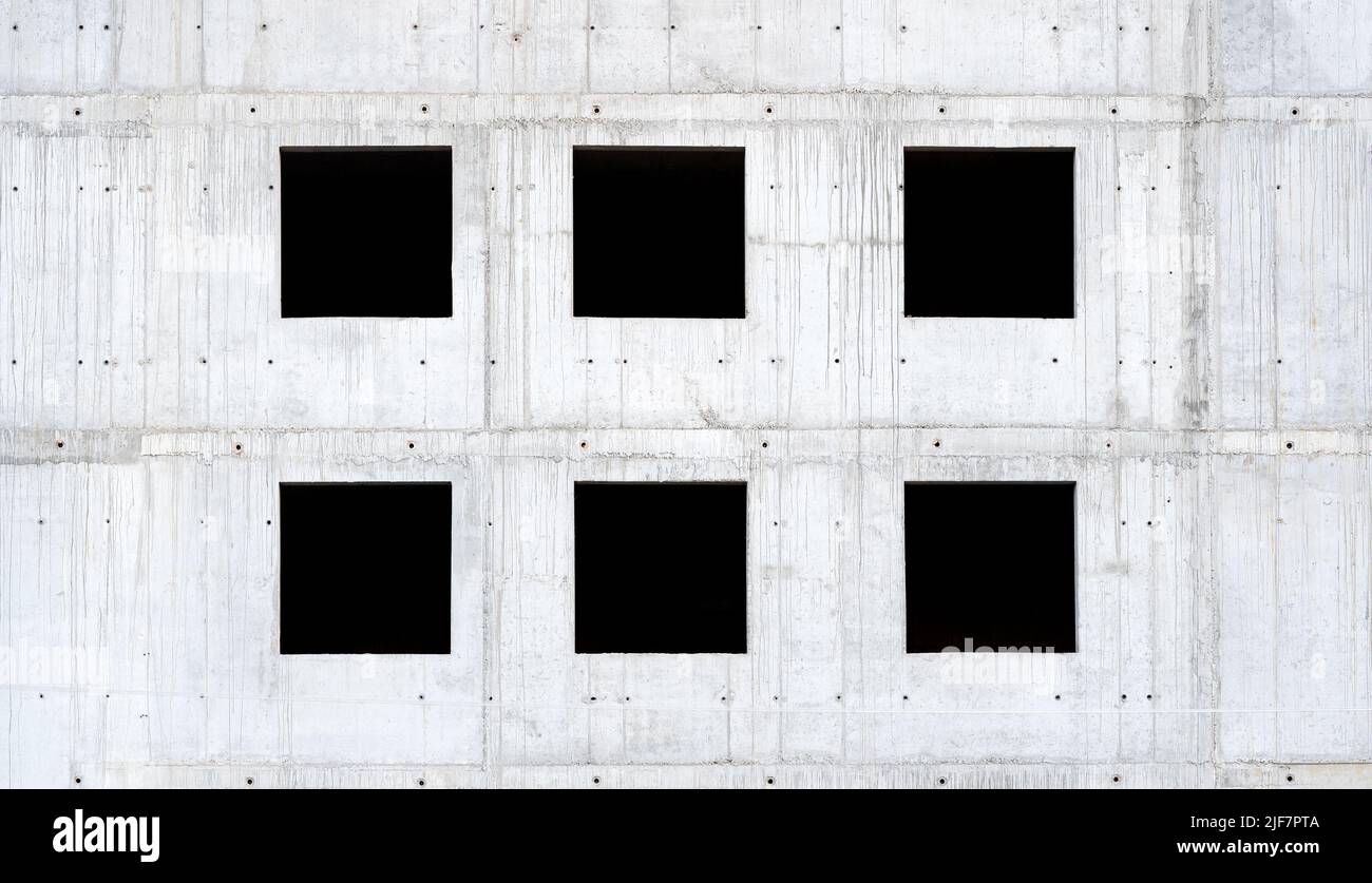 Six empty square windows, black window holes on a grey raw concrete ...