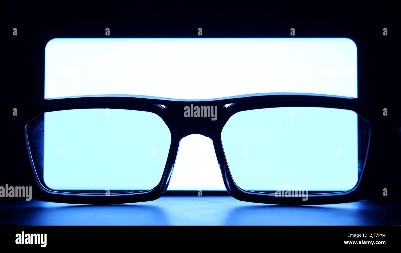 Glasses placed in front of a bright white smartphone screen. Mobile ...