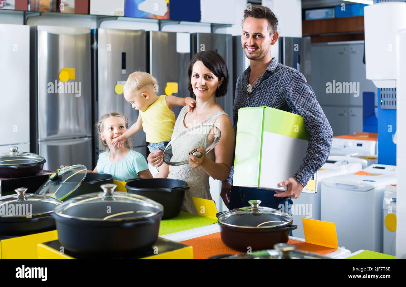 parents with two kids choosing kitchenware in home appliance store ...