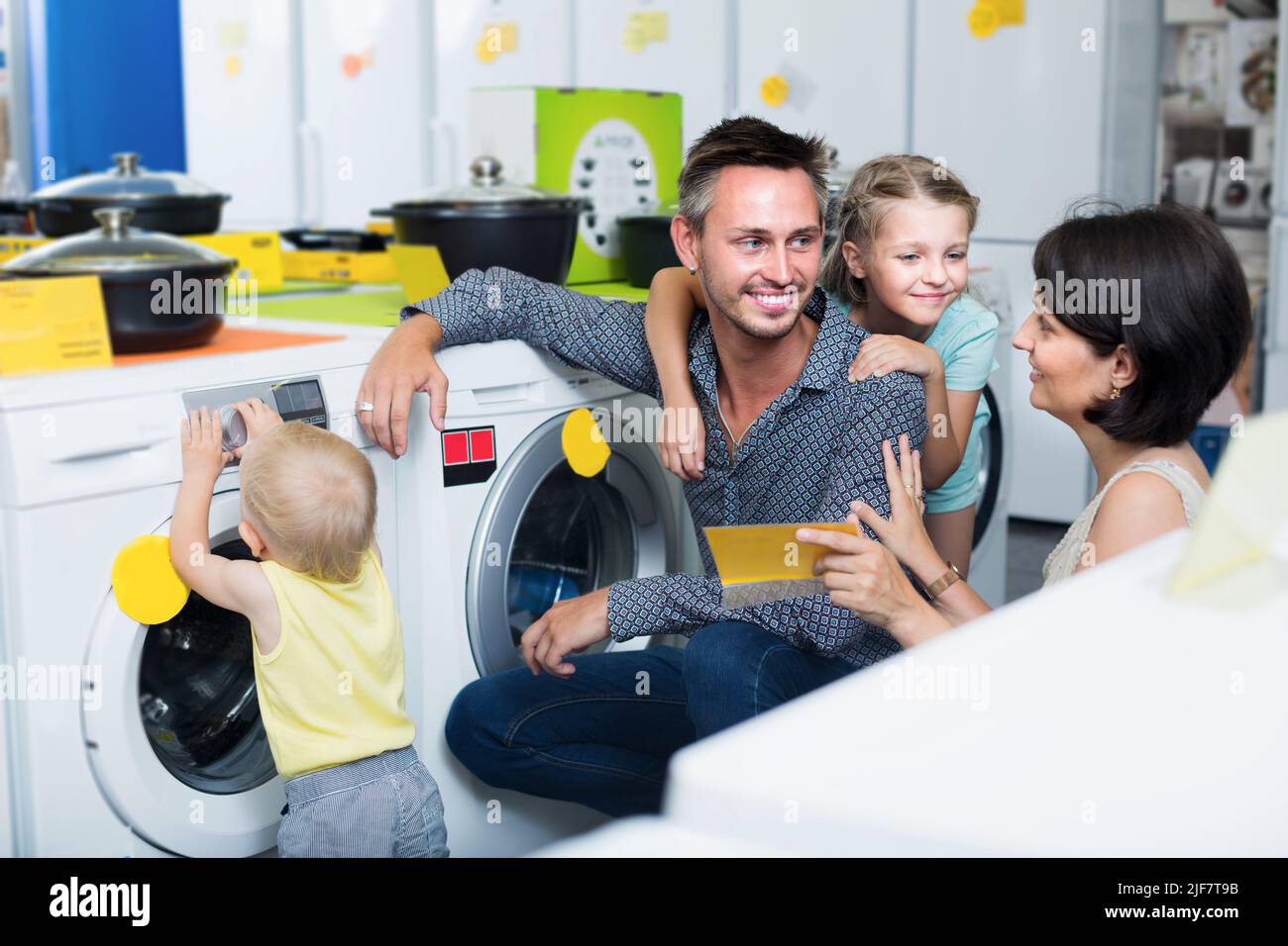 Smiling parents with kids shopping modern washer Stock Photo - Alamy
