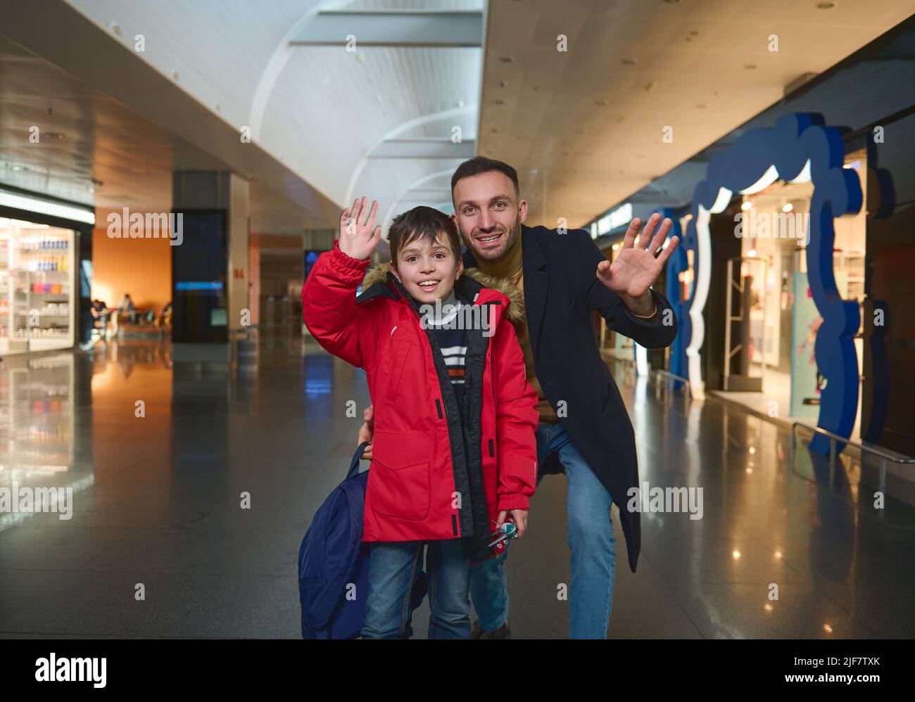 Happy Caucasian family of young cheerful dad and cute boy son waving ...