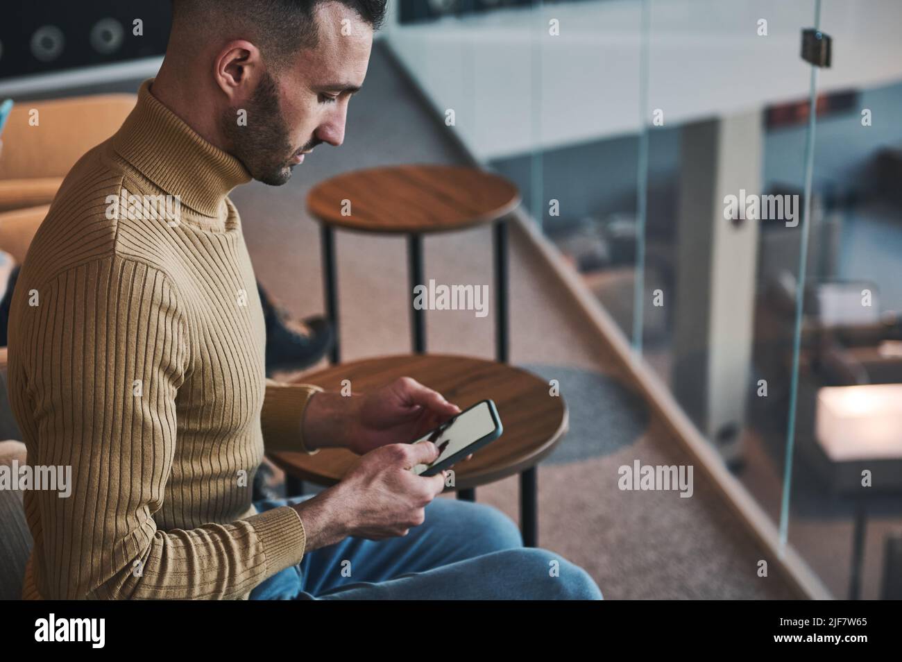 Multitasking young man of Middle-Eastern ethnicity using mobile phone ...