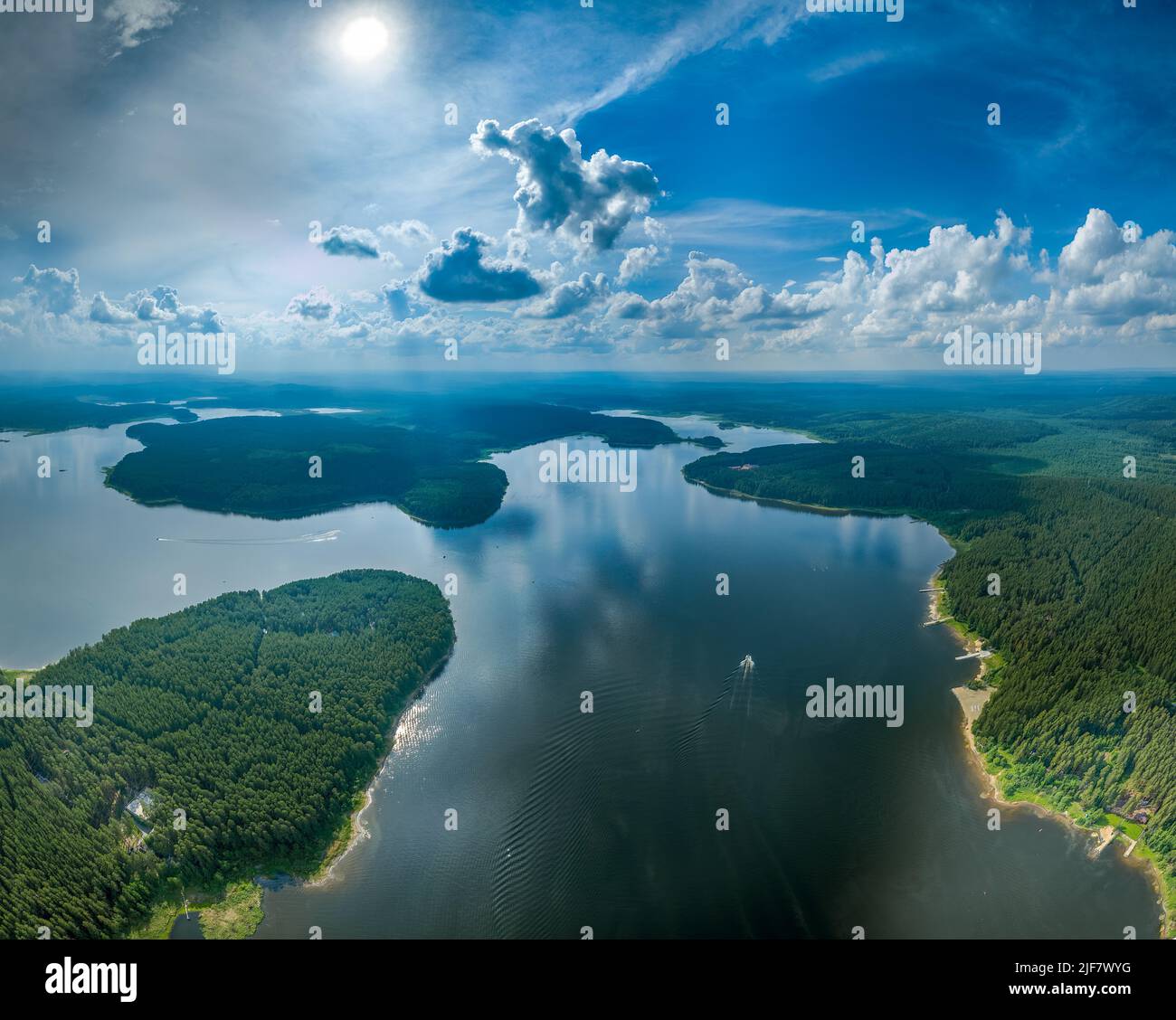 Big lake with green shores in bright sun light, aerial landscape ...