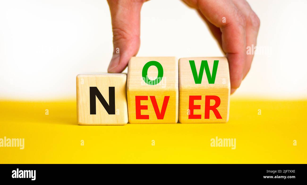 Now or never symbol. Businessman turns wooden cubes and changes the ...