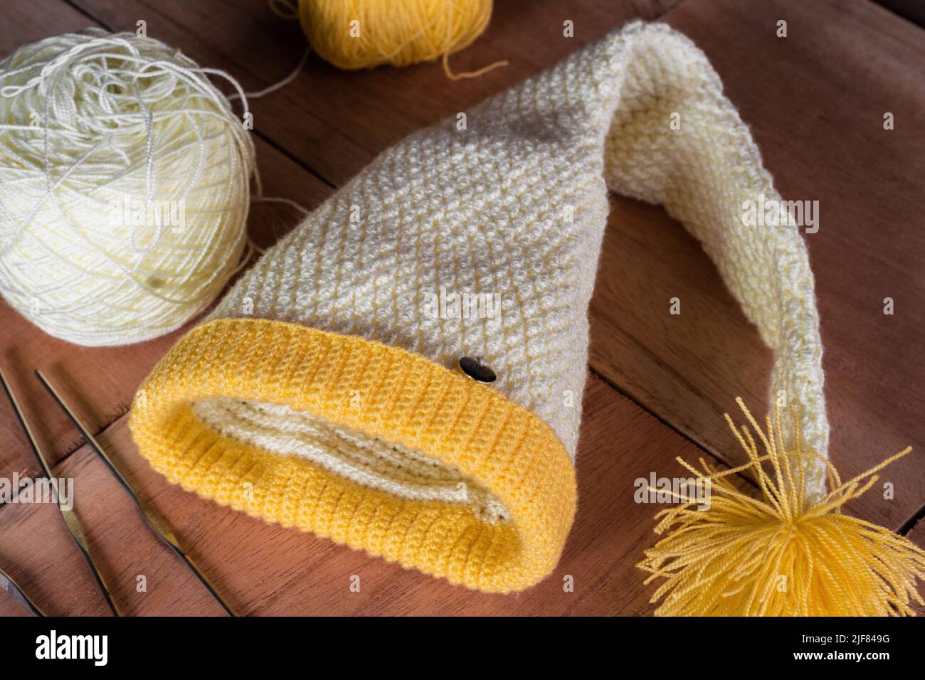 still life of a yellow crocheted hat with materials for designing and ...
