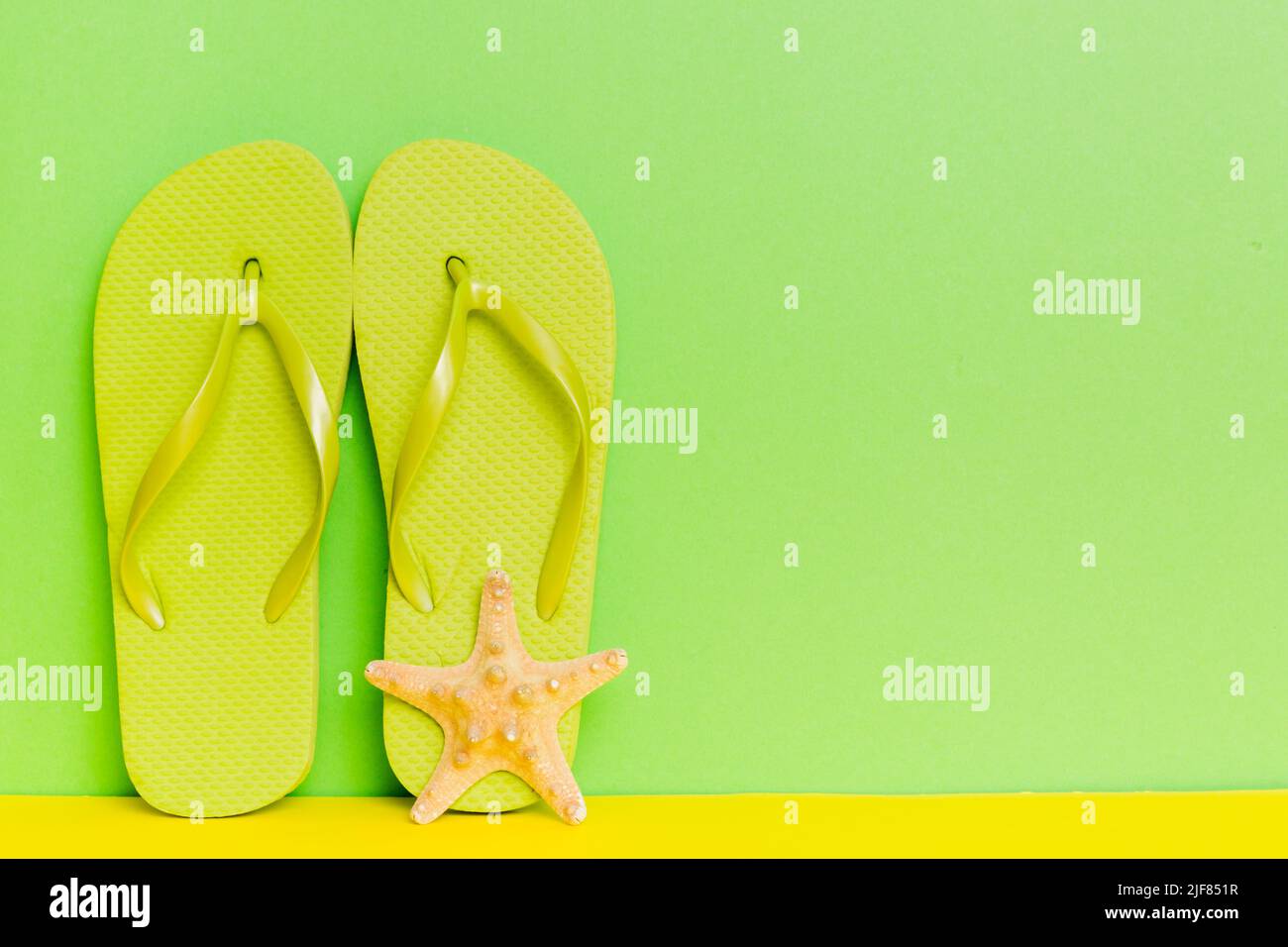 Beach accessories. Flip flops and starfish on colored background. Mock ...