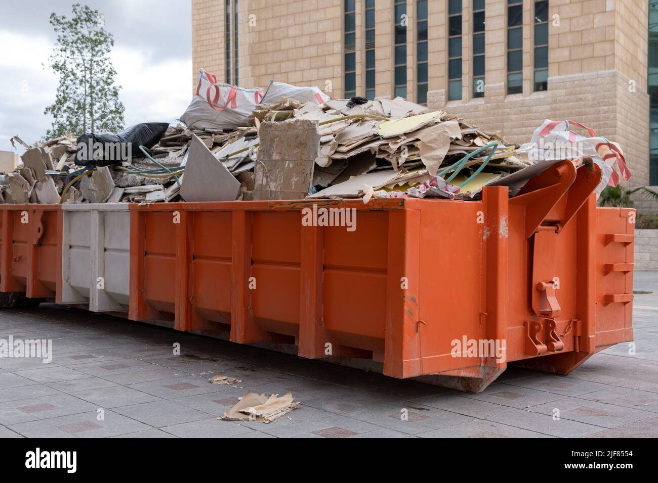 huge heap on metal Big Overloaded dumpster waste container filled with ...