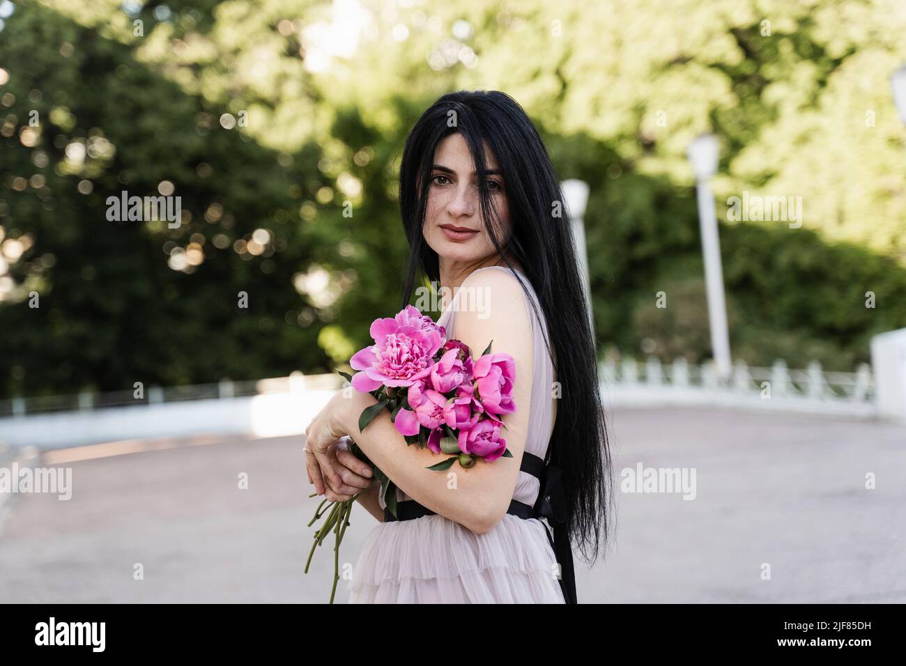 Adorable georgian woman with peonies bouquet of flowers is posing in ...