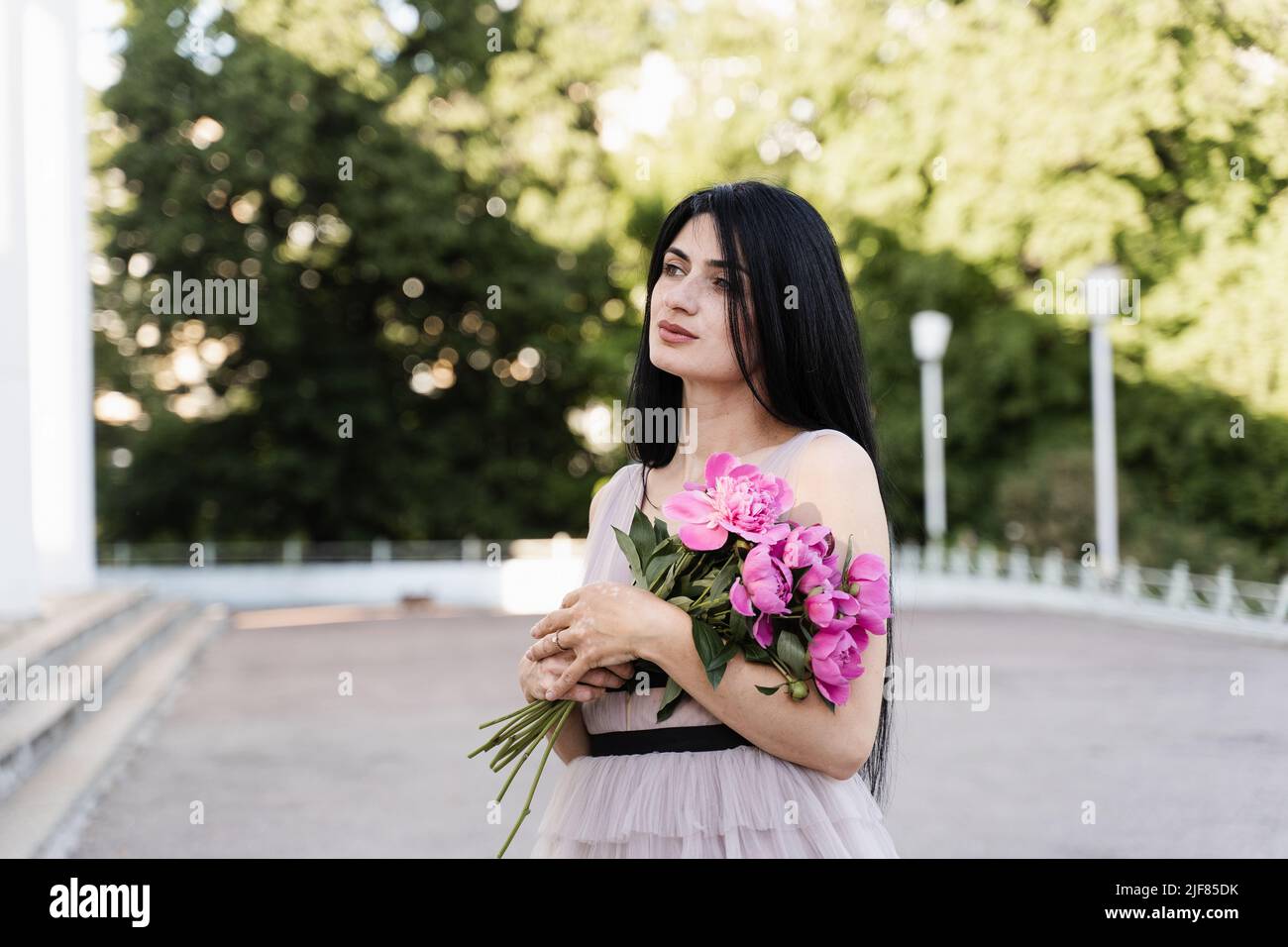 Adorable georgian woman with peonies bouquet of flowers is posing in ...