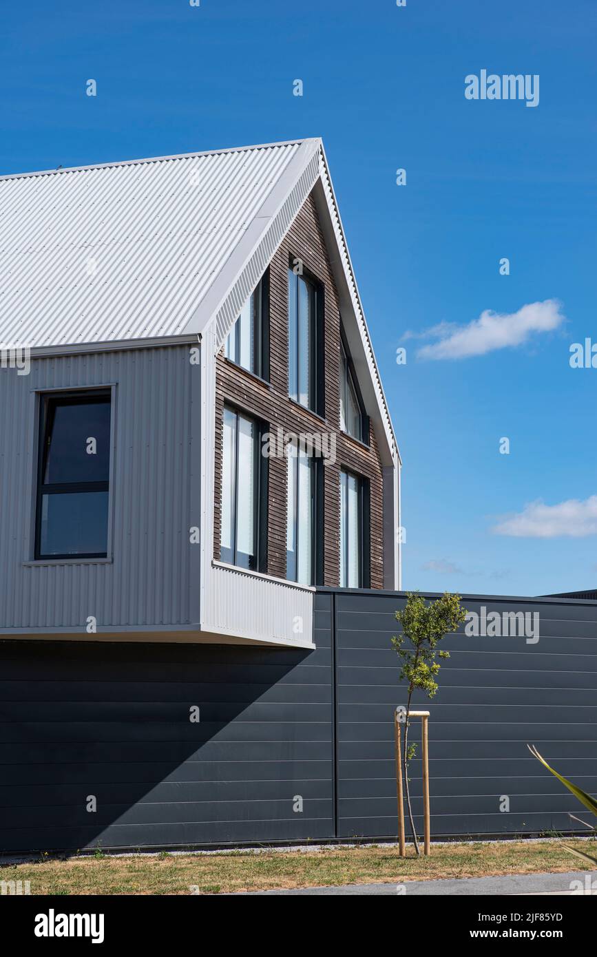 Modern house with a fence and a tree Stock Photo - Alamy