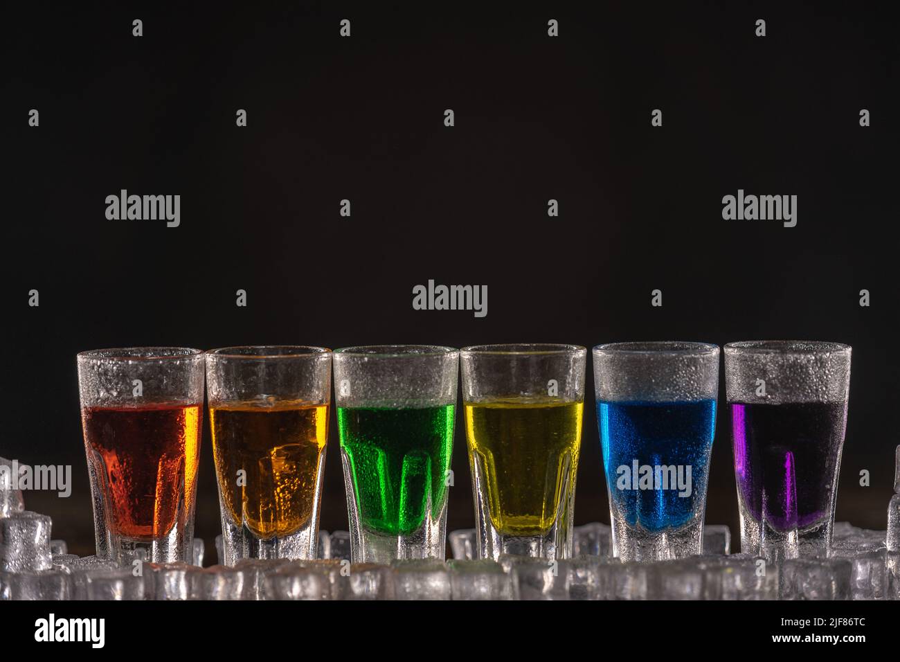 Shots with multicolored alcohol, standing in a row Stock Photo - Alamy