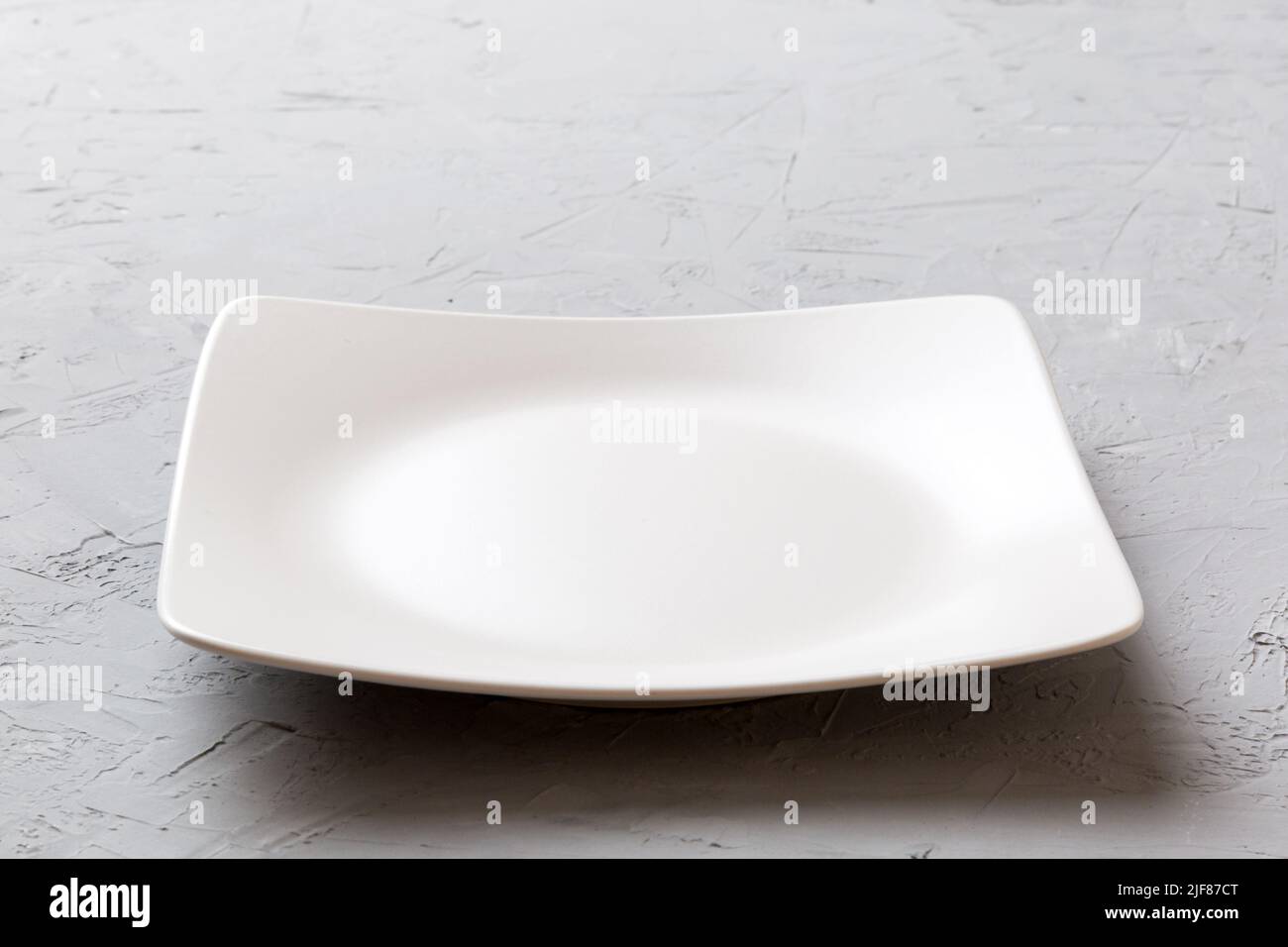Perspective view of empty square plate on cement background. Empty ...