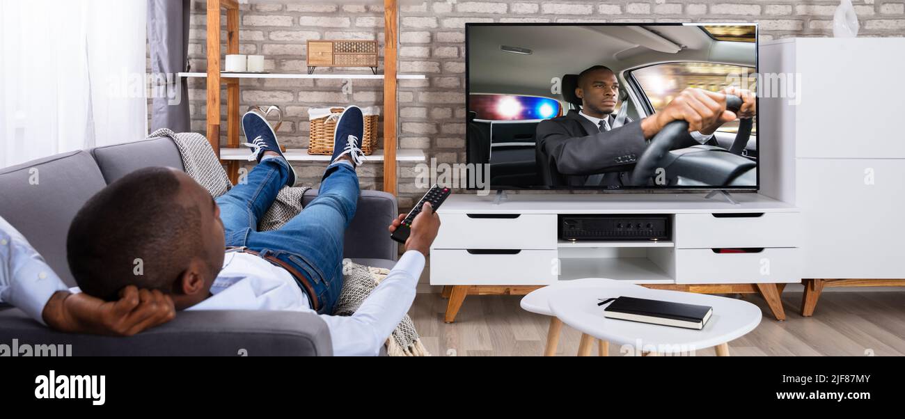 Man Lying On Sofa Watching Television At Home Stock Photo - Alamy