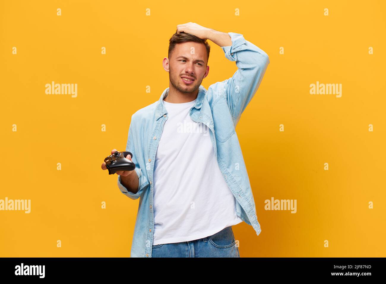 Upset unhappy tanned handsome man in blue basic t-shirt lose game with ...