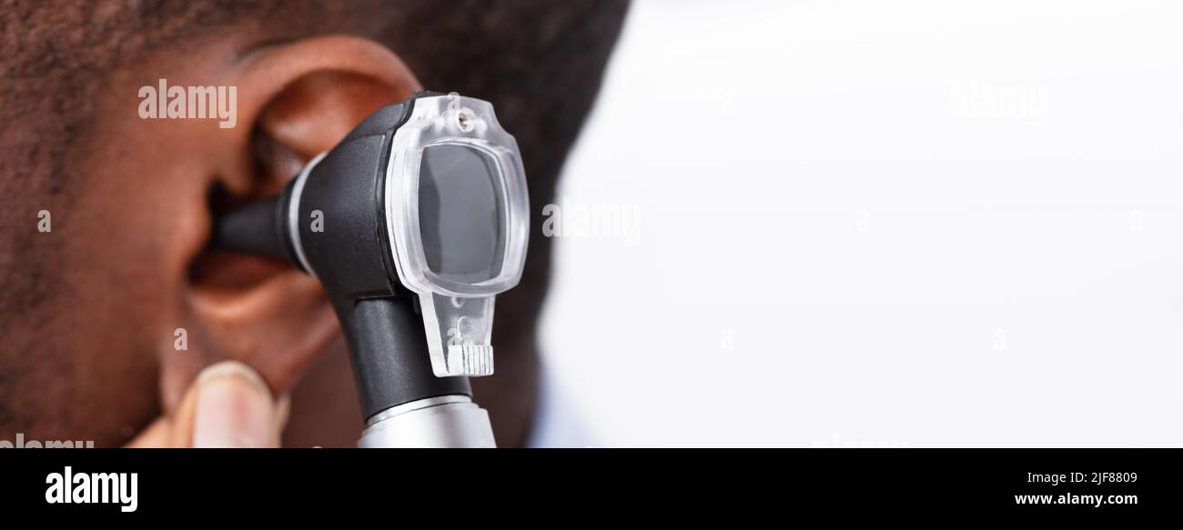African Doctor Examining Male Patient's Ear With Otoscope Stock Photo ...