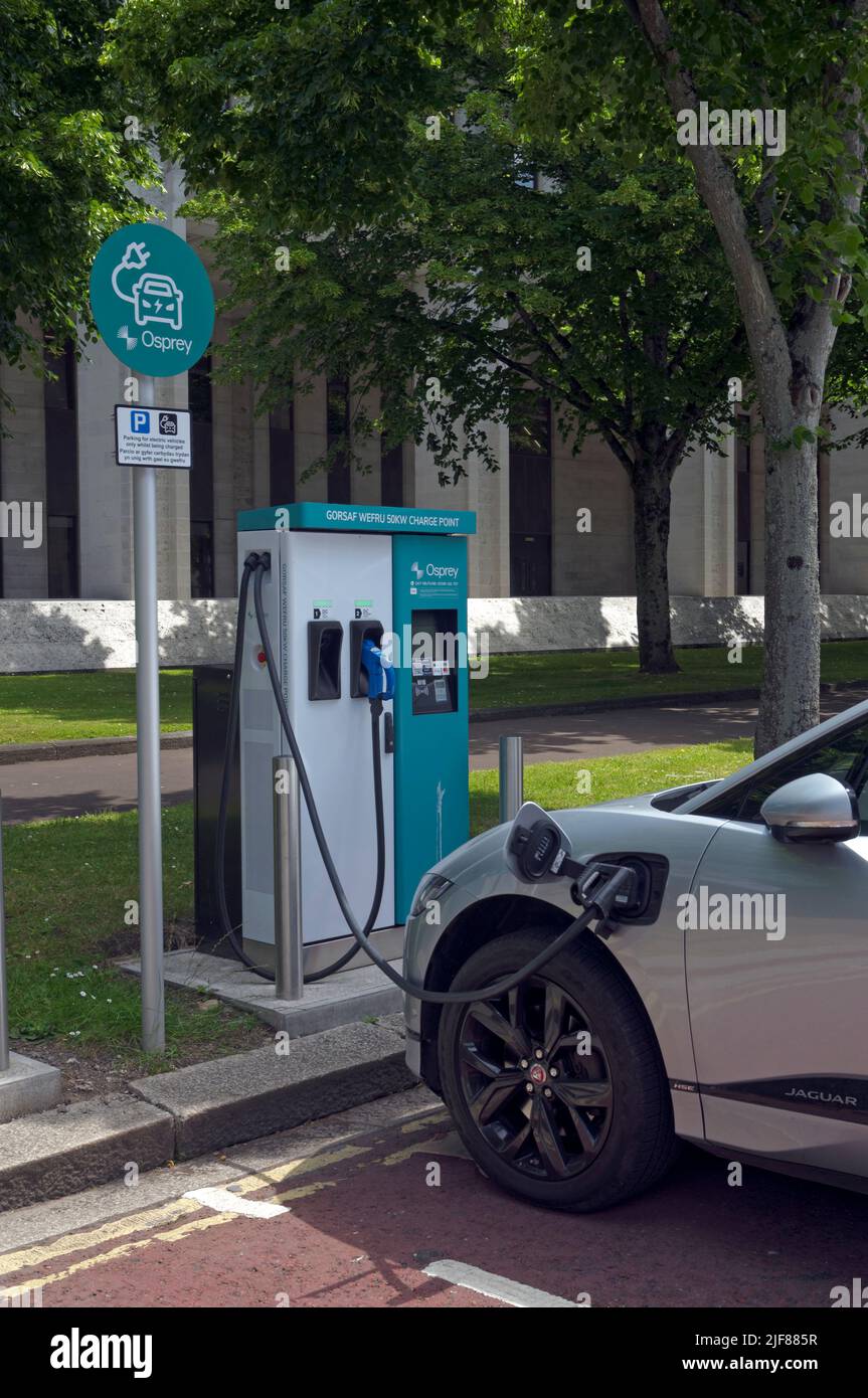 Electric car recharging point, with car parked and charging. Central ...