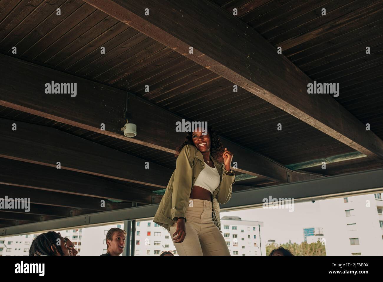 Happy young woman dancing by friends below bridge Stock Photo - Alamy