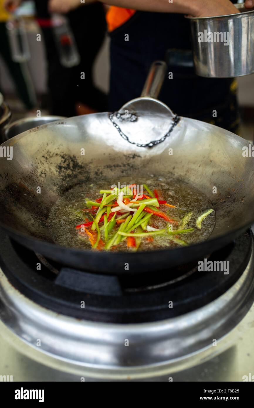 red and green peppers are fried in oil in a frying pan Stock Photo - Alamy