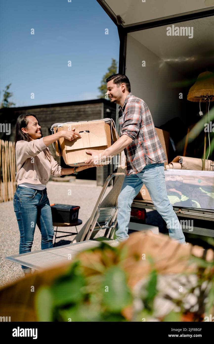 Couple unloading box from truck while relocating to new house Stock ...