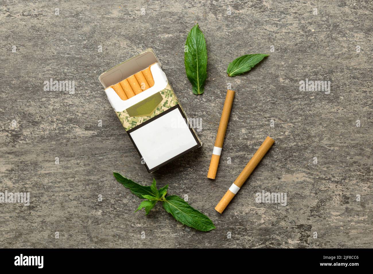 Pack of menthol cigarettes and fresh mint on colored table, Menthol ...