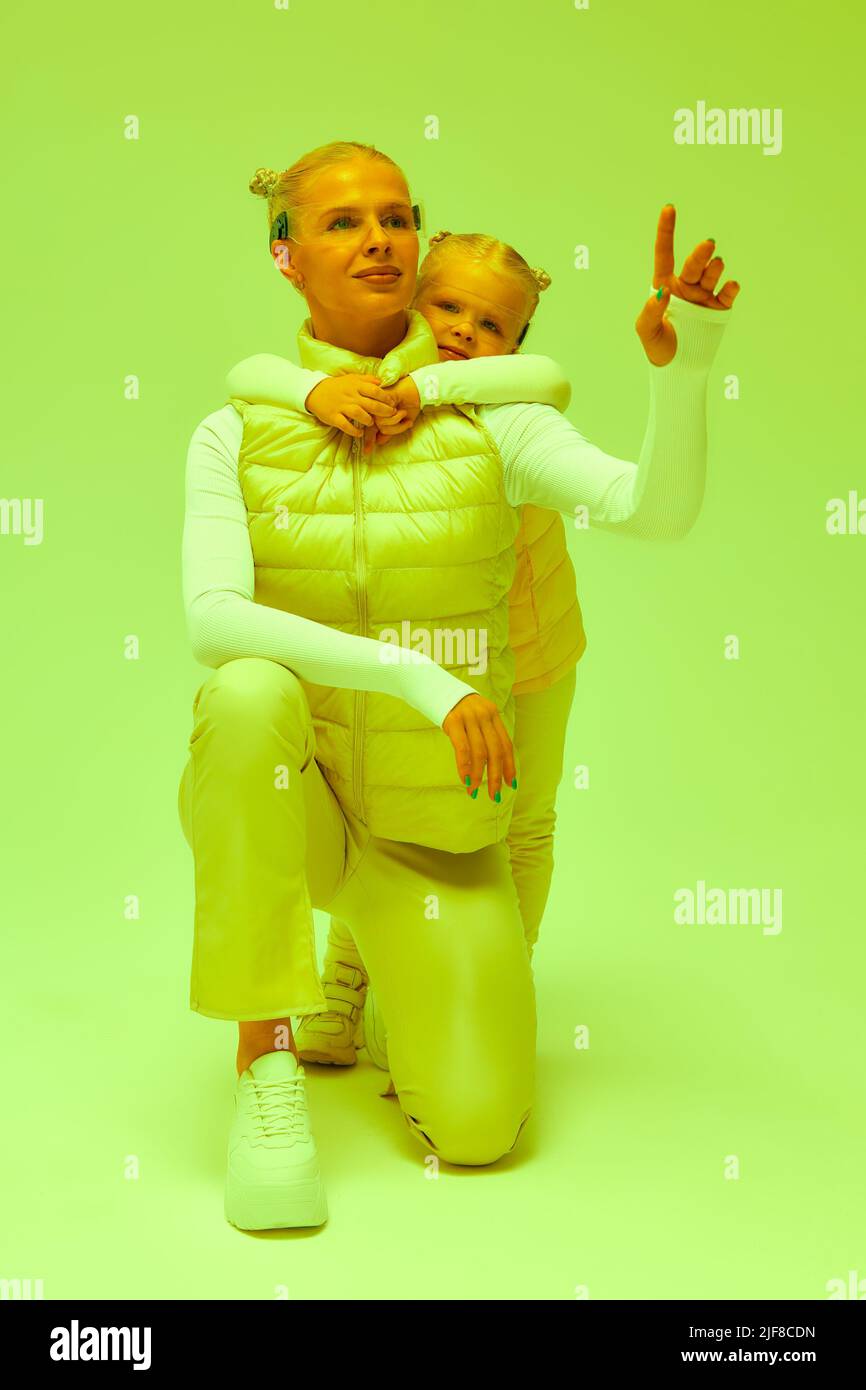 Woman with little girl in futuristic costume wearing smart led glasses ...