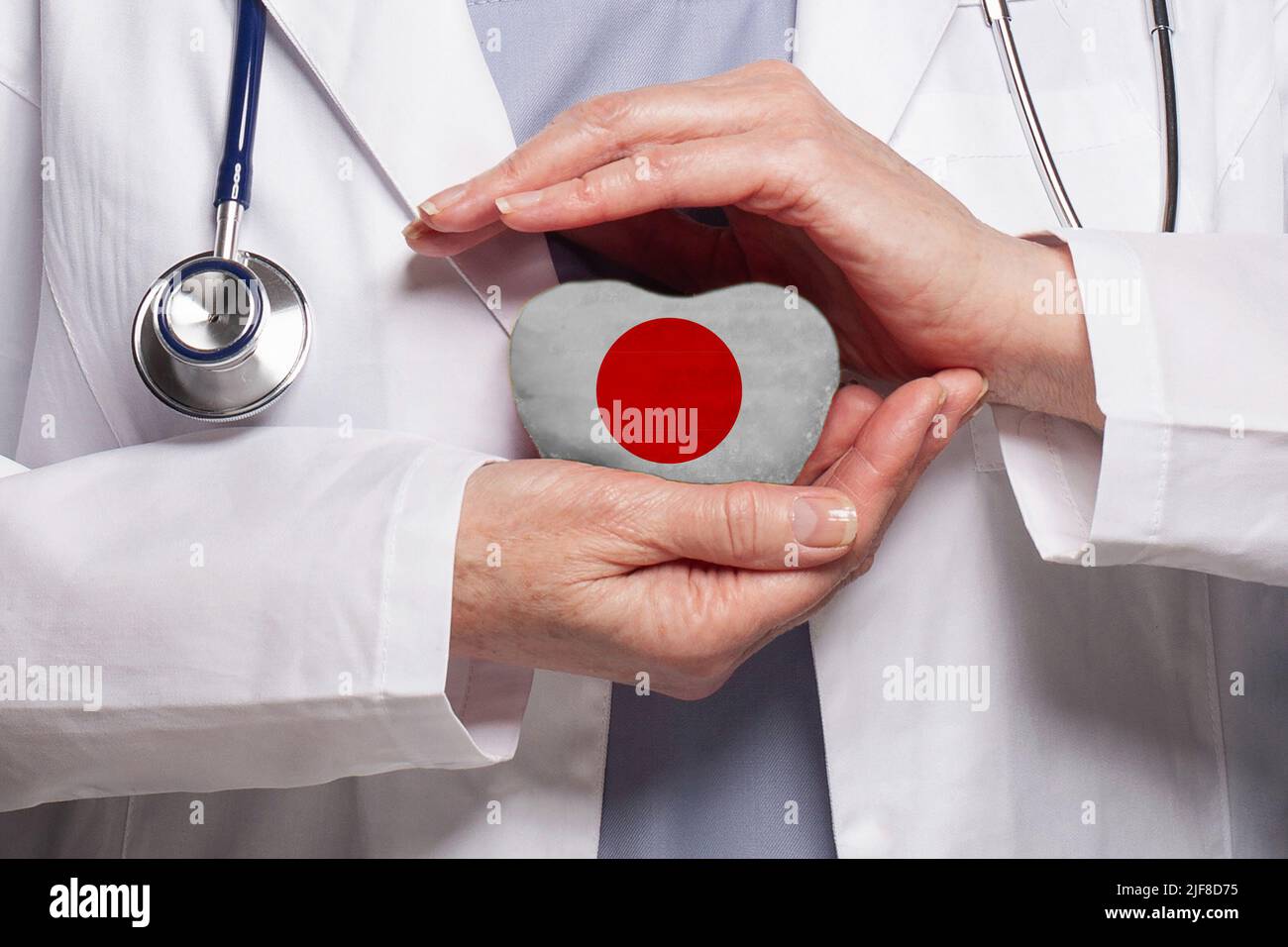 Japanese doctor holding heart with flag of Japan background. Healthcare ...