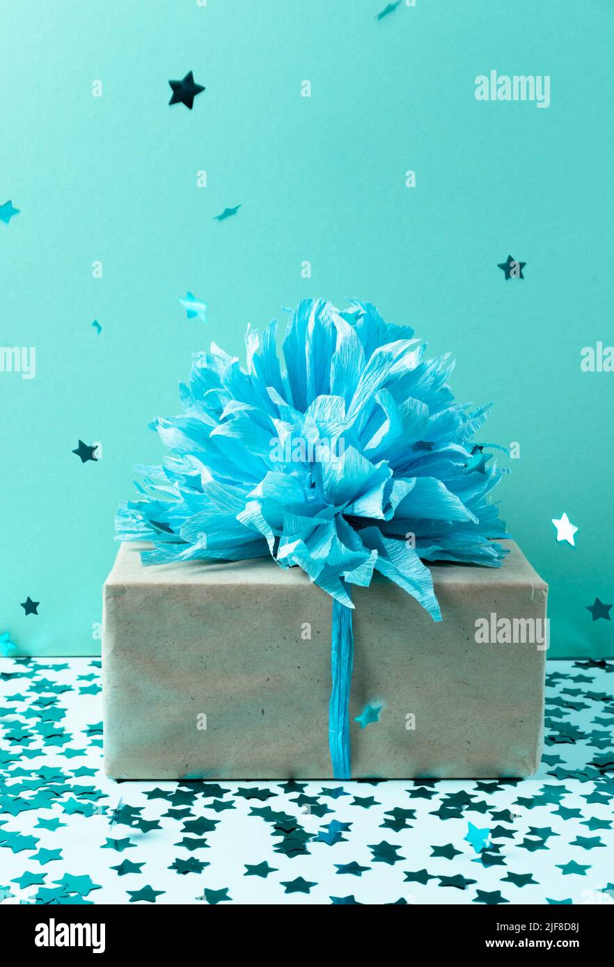 Kraft paper gift box with blue ribbon bow on blue background with ...