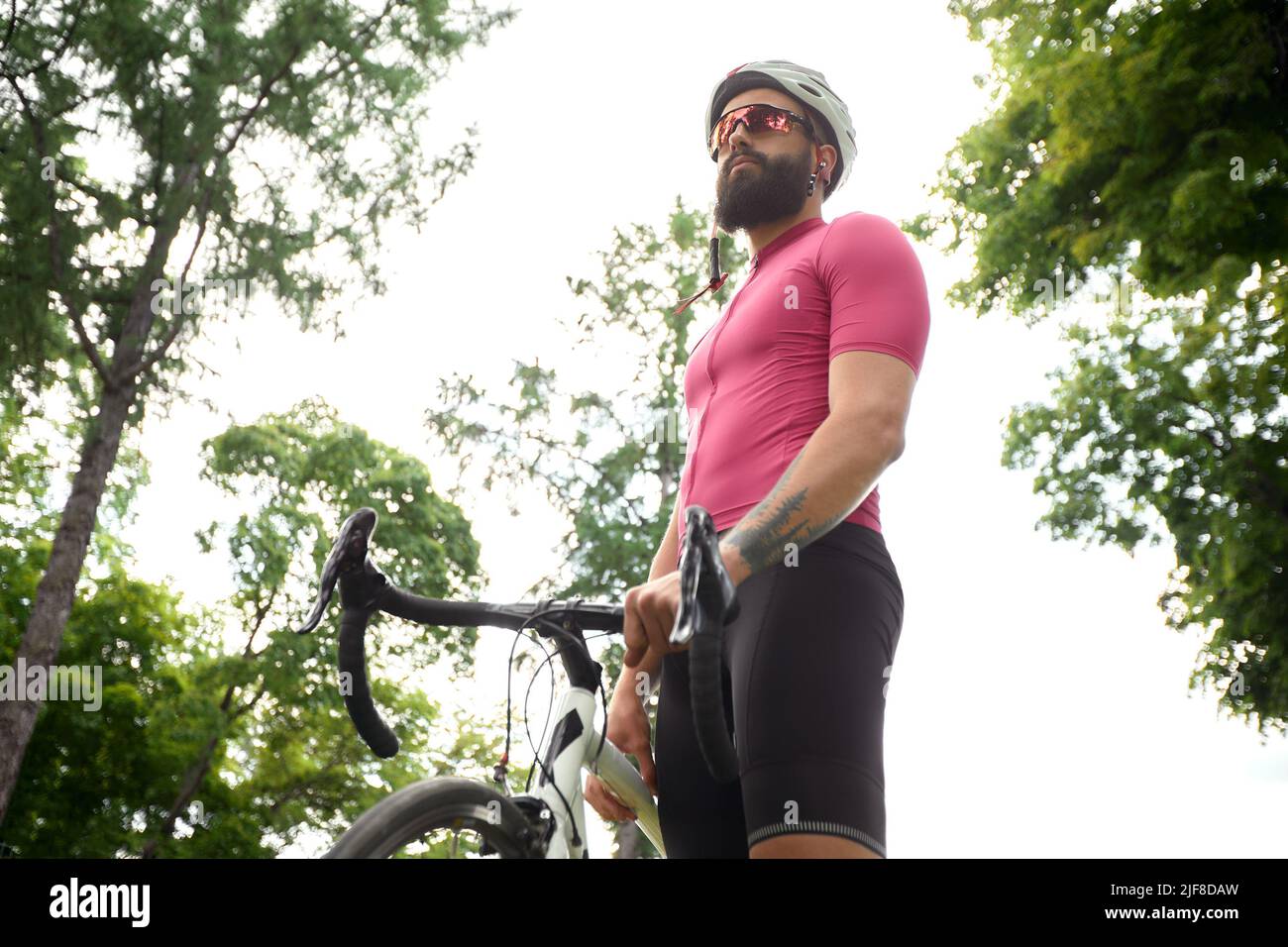 Strong Male cyclist in sportswear, glasses and protective helmet ...
