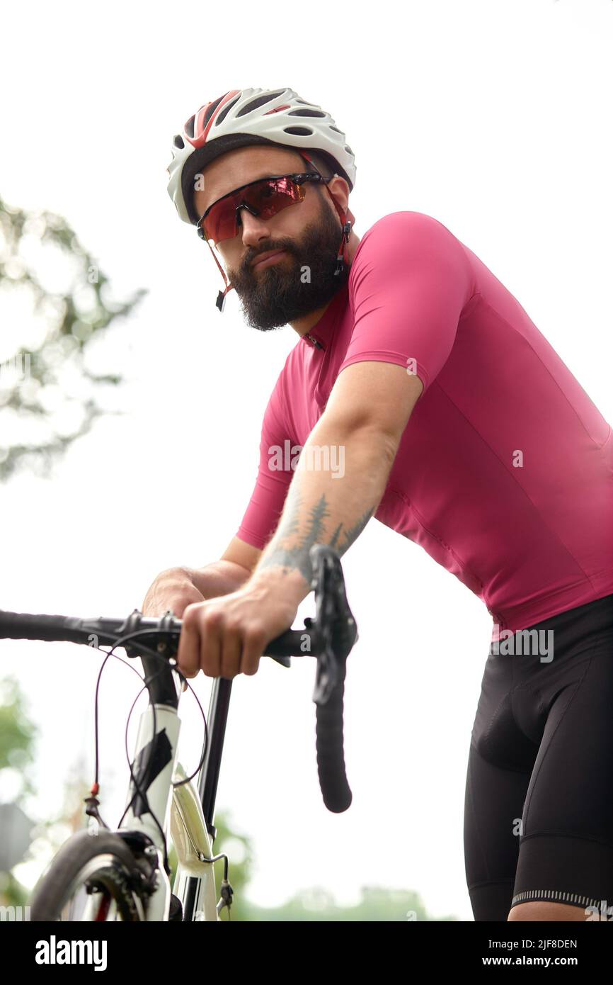 Strong Male cyclist in sportswear, glasses and protective helmet ...