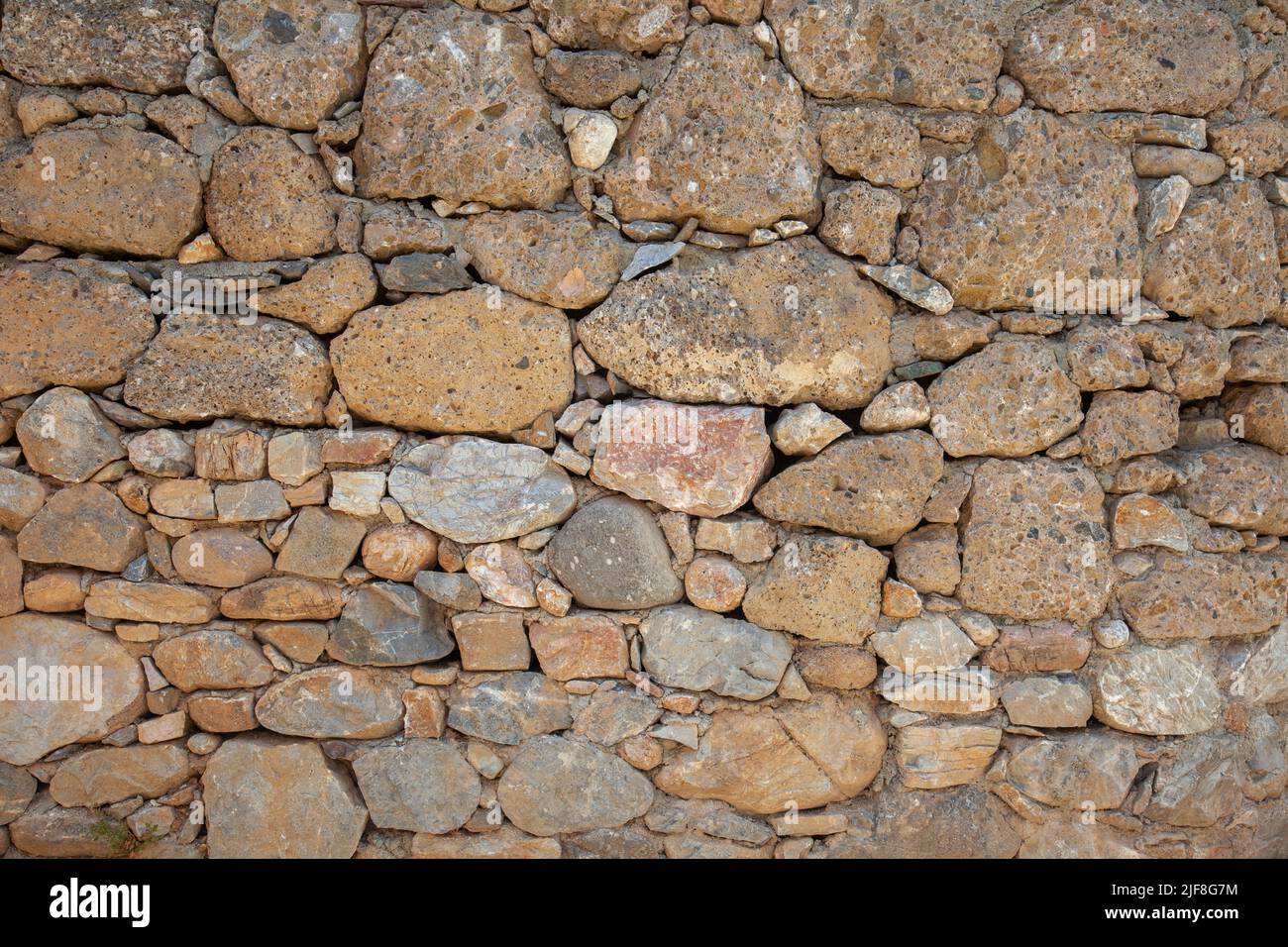 An old stone wall made using different types of stone. Stone wall ...