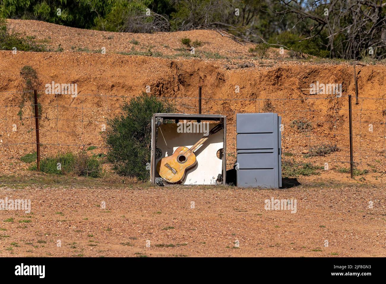 An old wooden guitar on display in a box by the roadside in Rubyvale ...