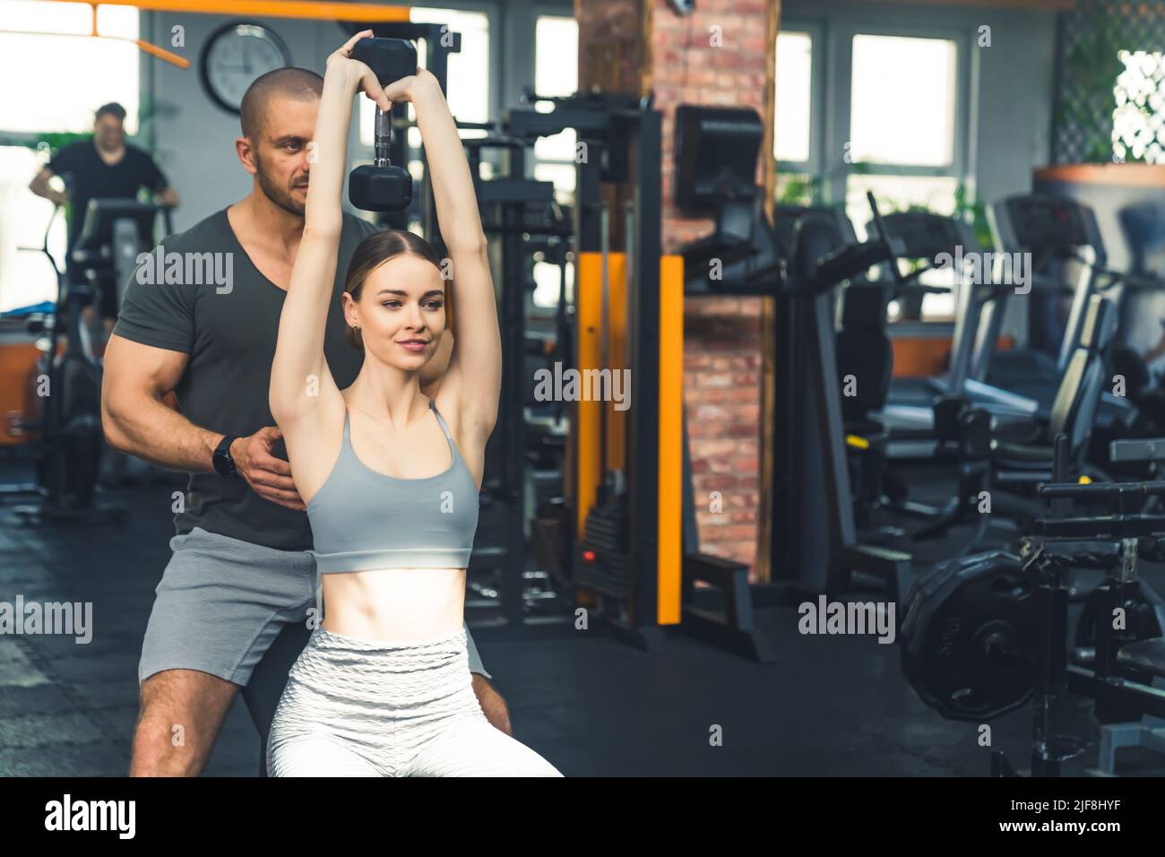 Beautiful dark-haired slim woman in her 20s sitting on a bench and ...