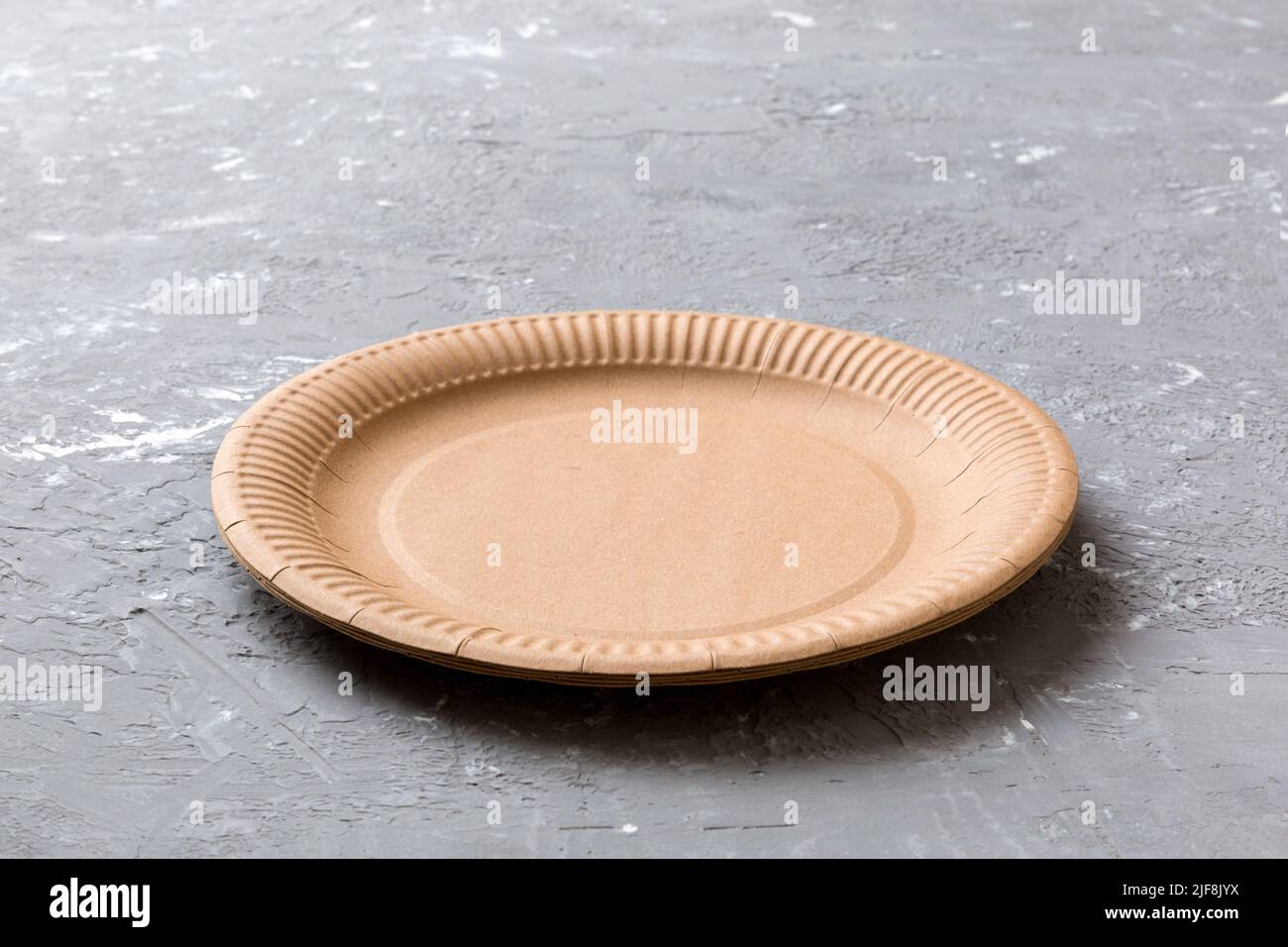 Perspective view of eco paper plate on cement background. Empty space ...