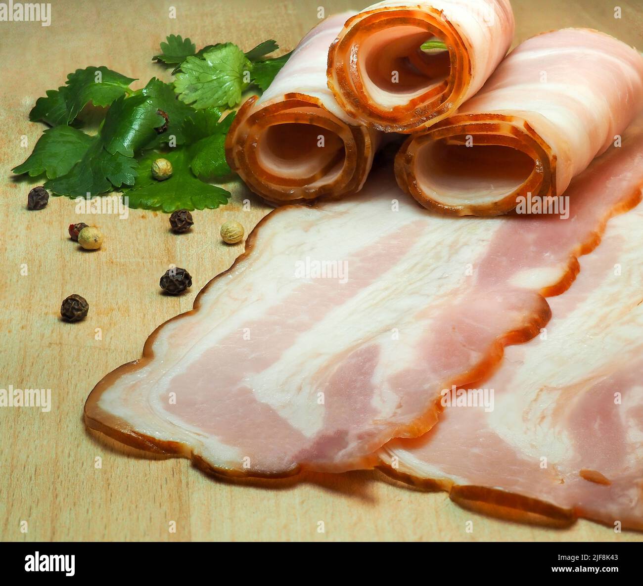 Curvy cut folded into rolls. Pork on a kitchen board with parsley ...