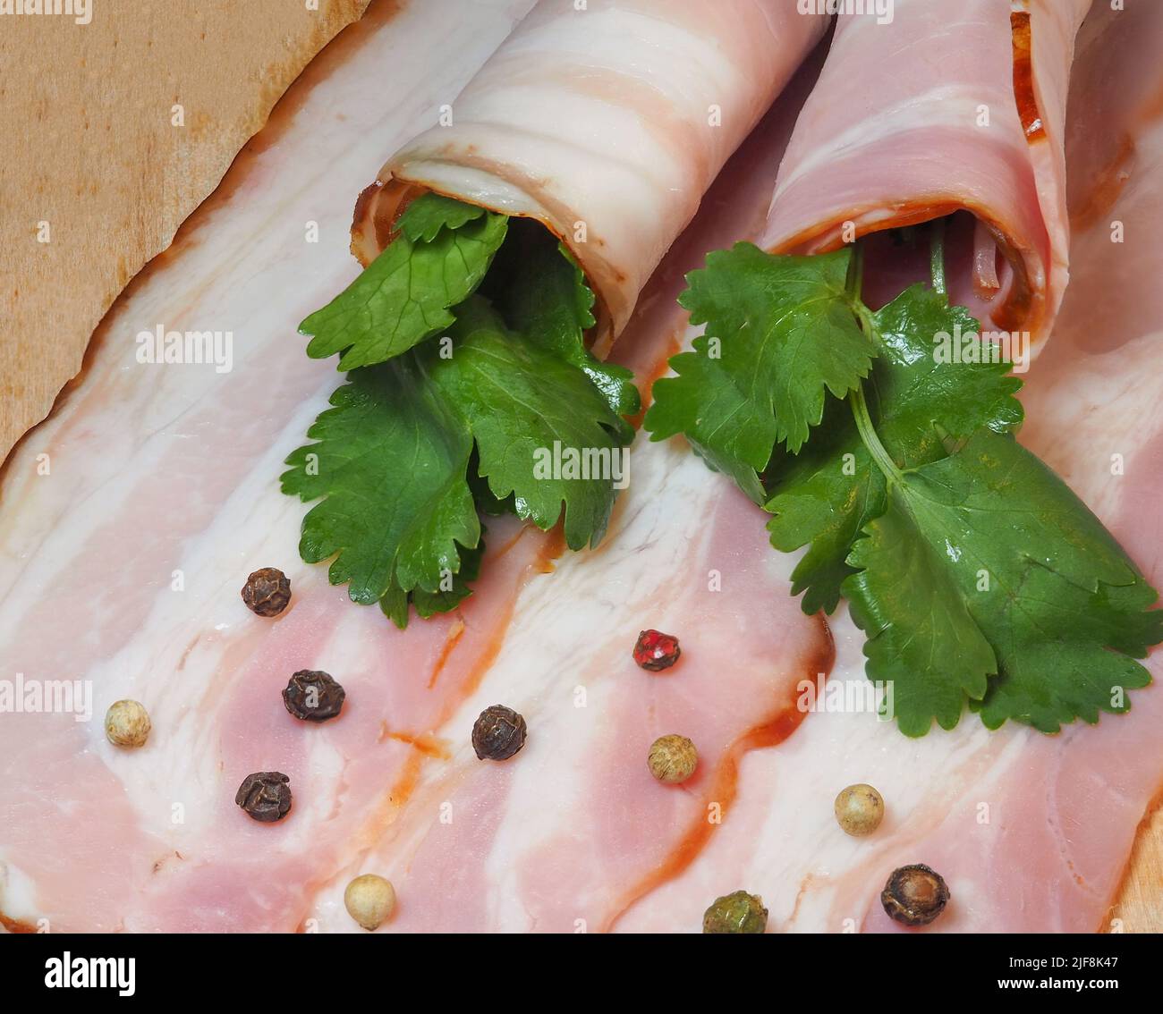 Curvy cut folded into rolls. Pork on a kitchen board with parsley ...