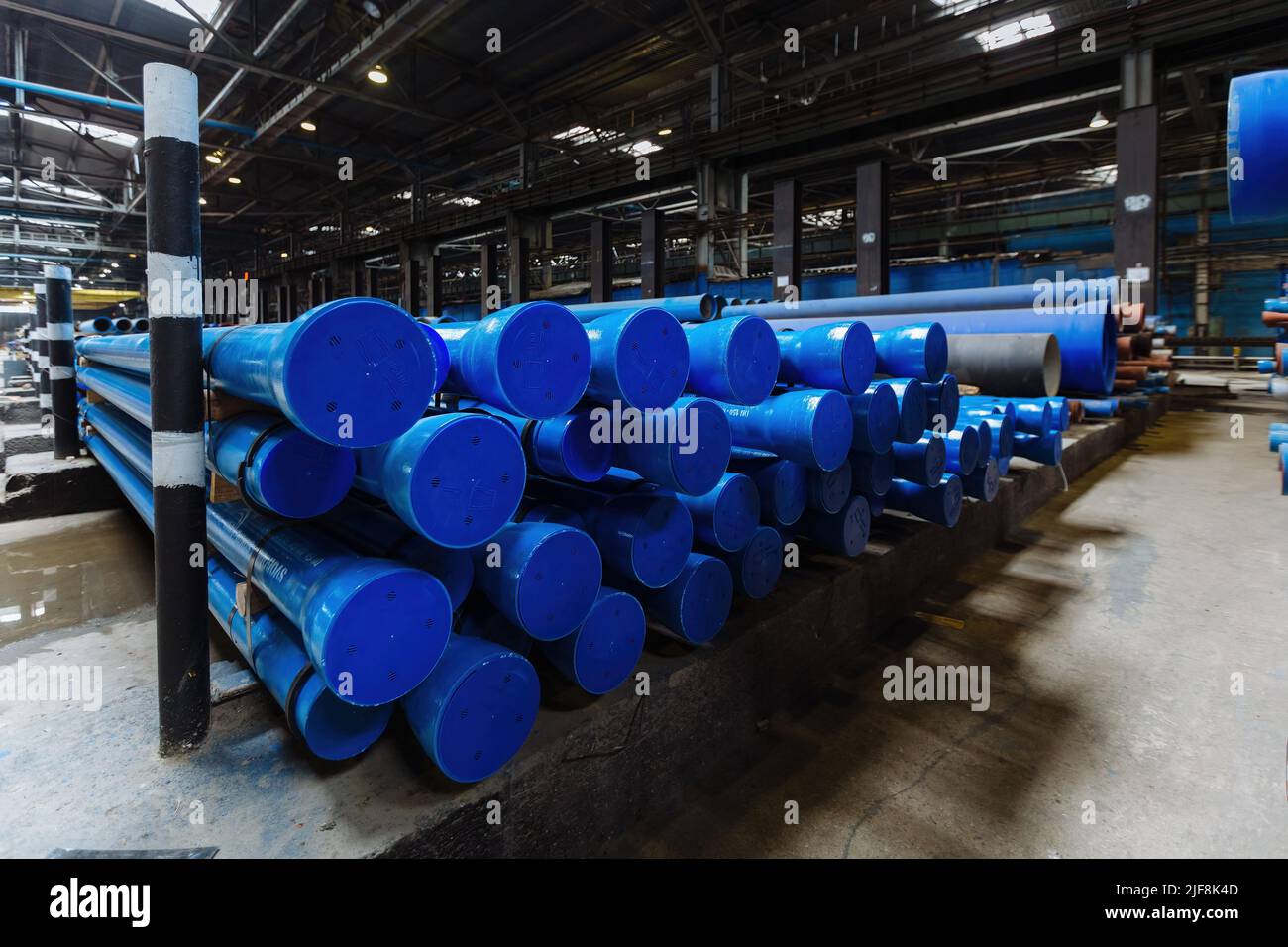 New blue colored cast iron pipes with caps for pipeline construction in ...