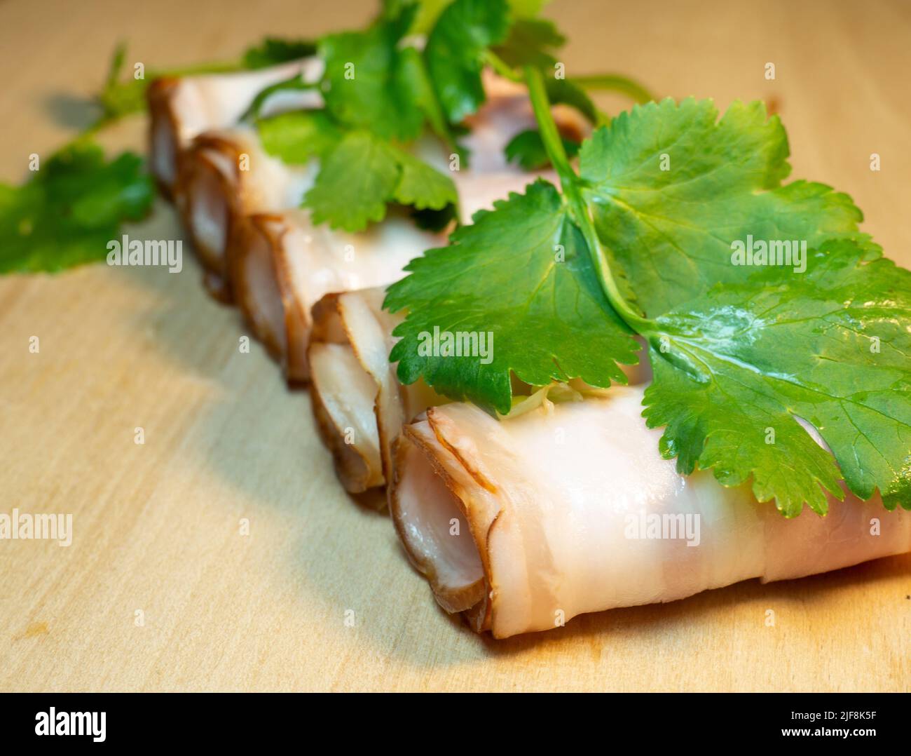 Curvy cut folded into rolls. Pork on a kitchen board with parsley ...