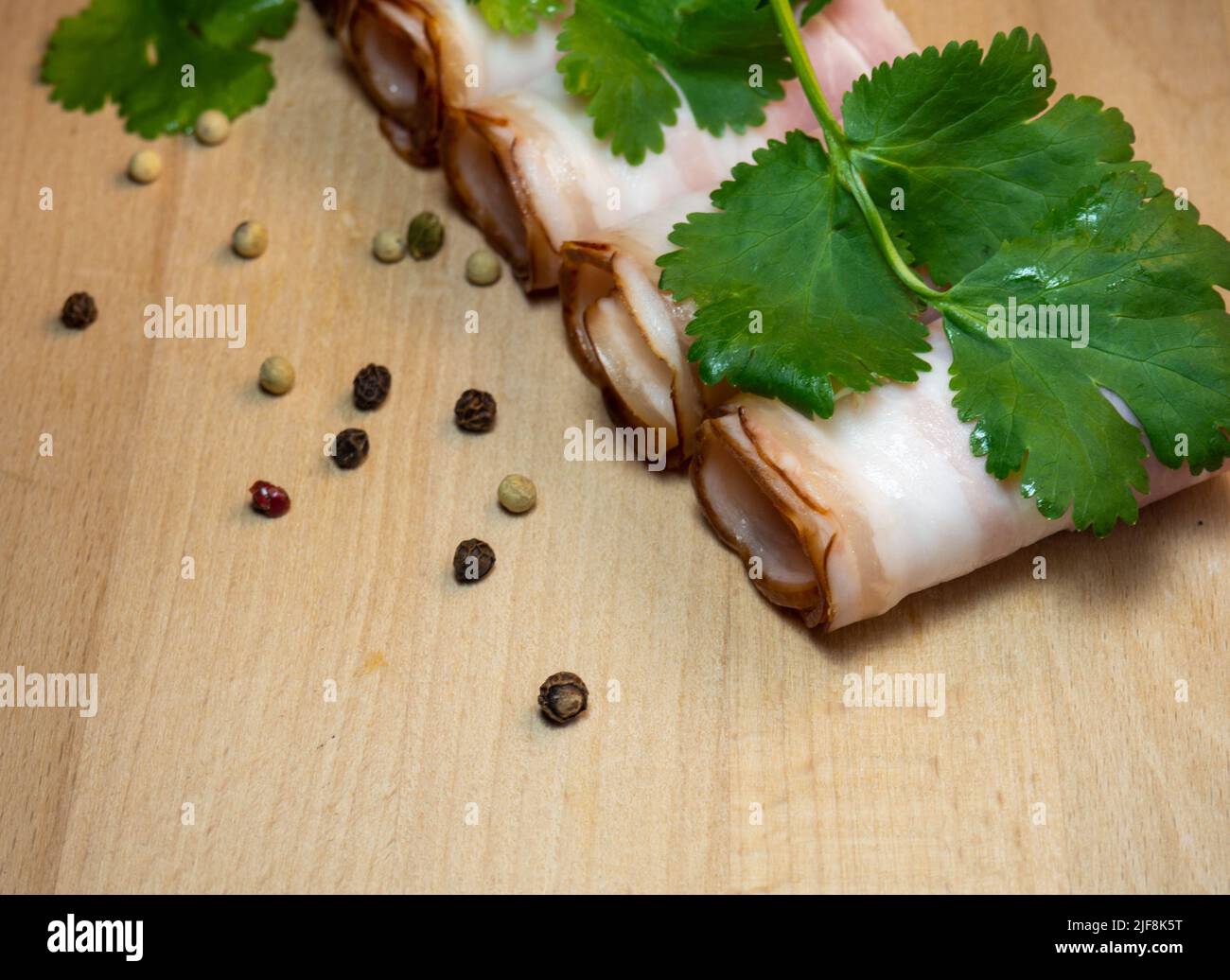 Curvy cut folded into rolls. Pork on a kitchen board with parsley ...