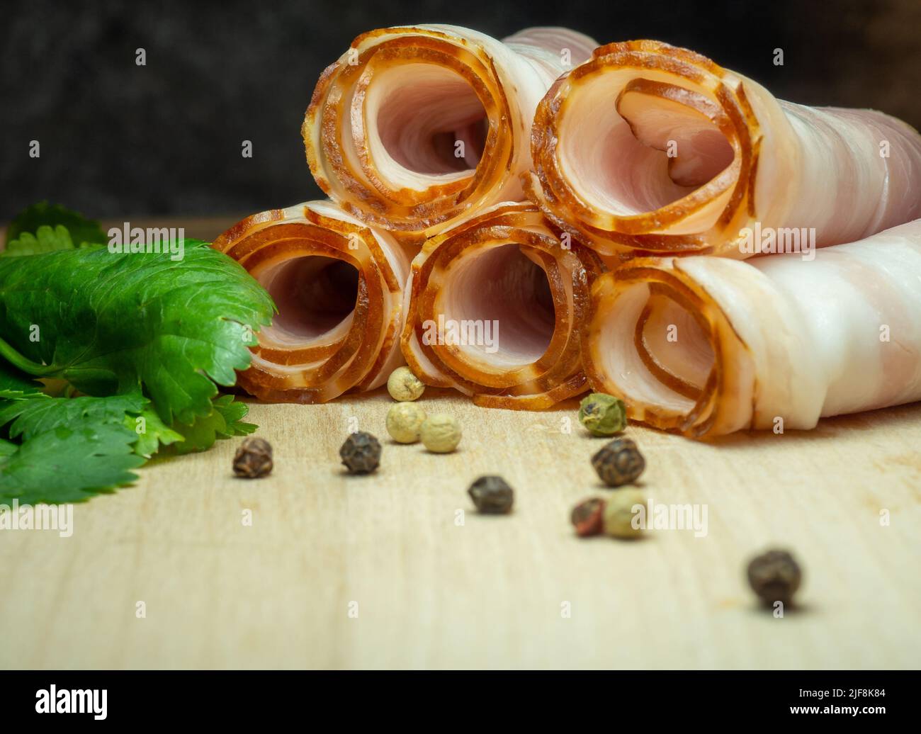 Curvy cut folded into rolls. Pork on a kitchen board with parsley ...