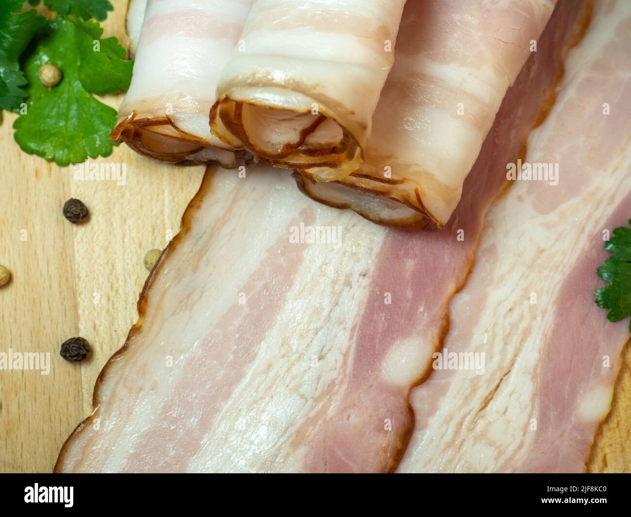 Curvy cut folded into rolls. Pork on a kitchen board with parsley ...