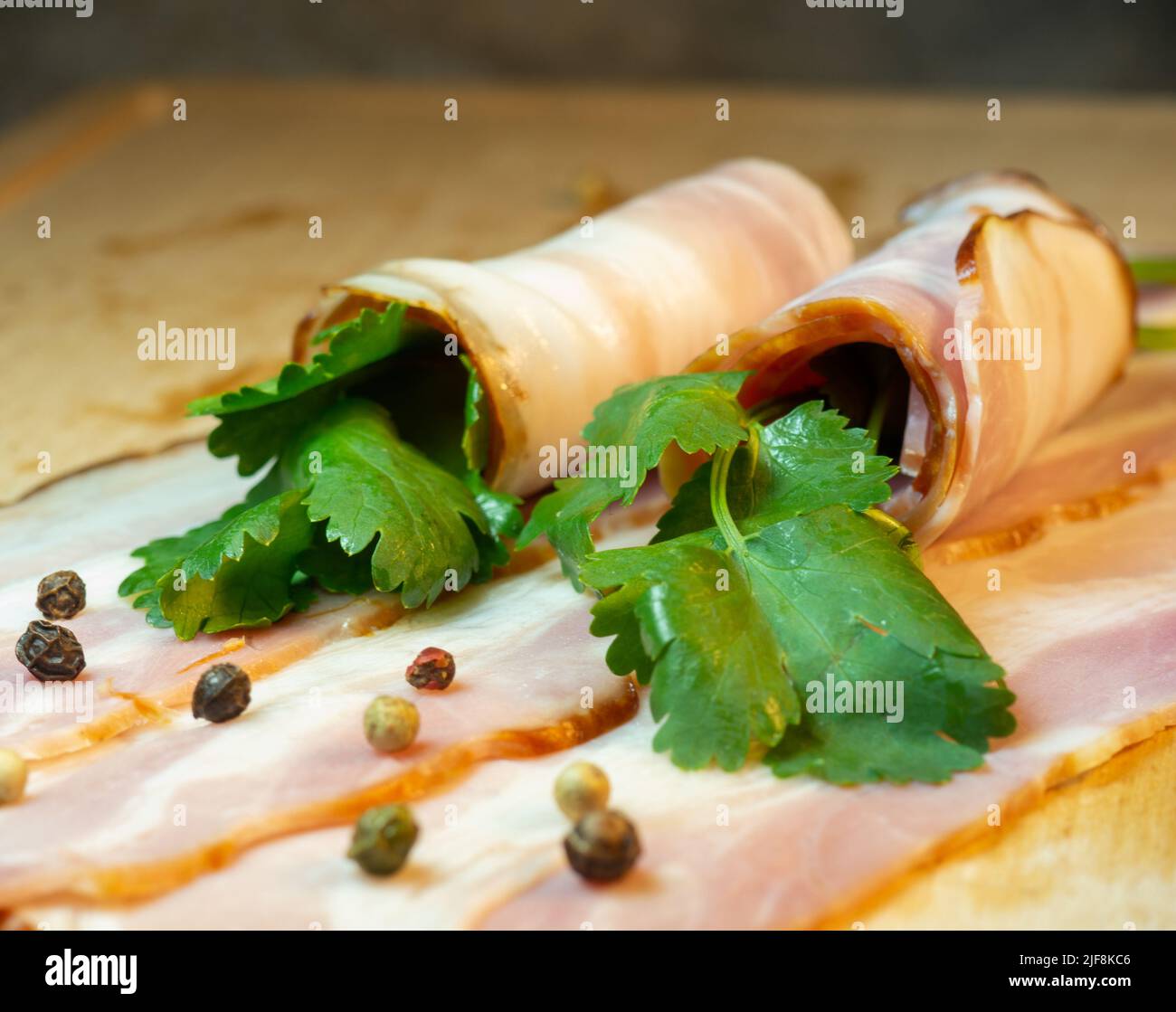 Curvy cut folded into rolls. Pork on a kitchen board with parsley ...
