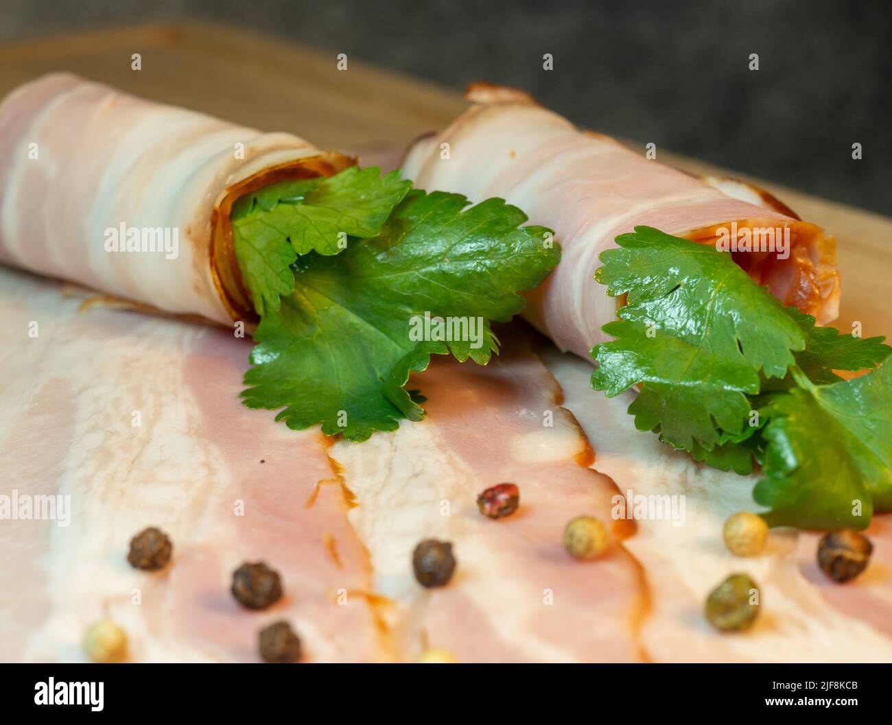 Curvy cut folded into rolls. Pork on a kitchen board with parsley ...