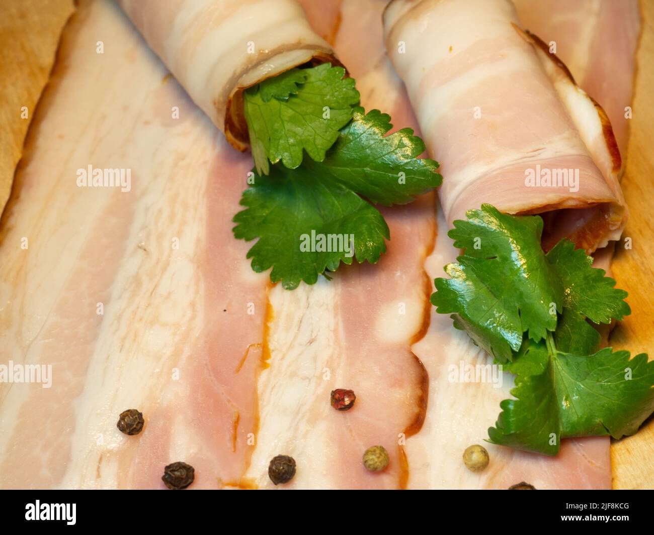 Curvy cut folded into rolls. Pork on a kitchen board with parsley ...