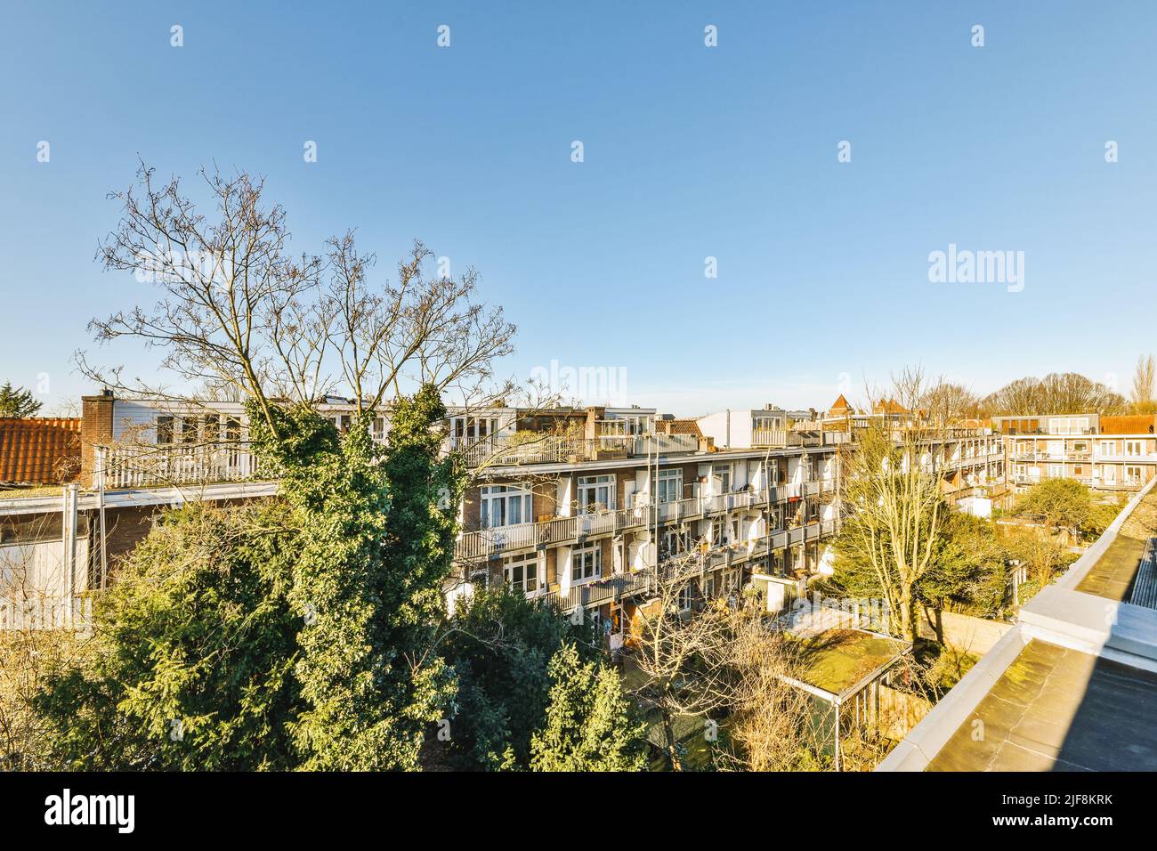 Panoramic view of brick houses with balconies and patios with trees on ...