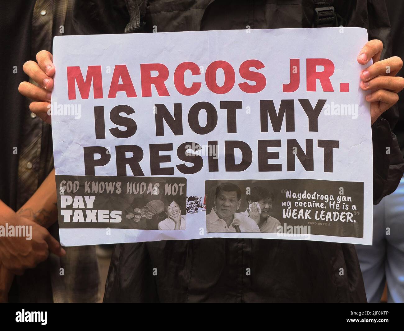 Manila, Philippines. 30th June, 2022. A protester holds a placard with ...
