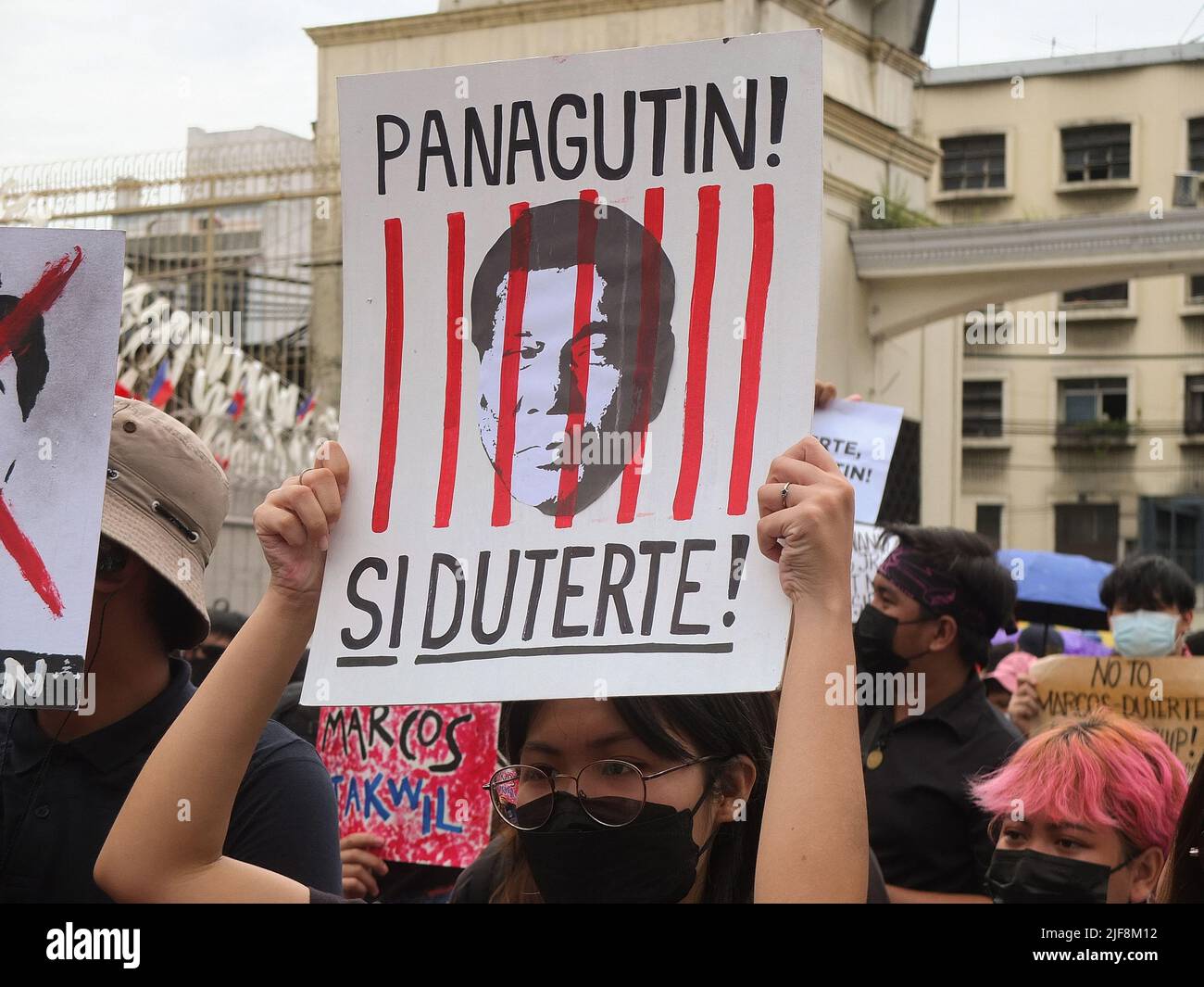 A protester holds a placard with a picture of the former Philippine ...