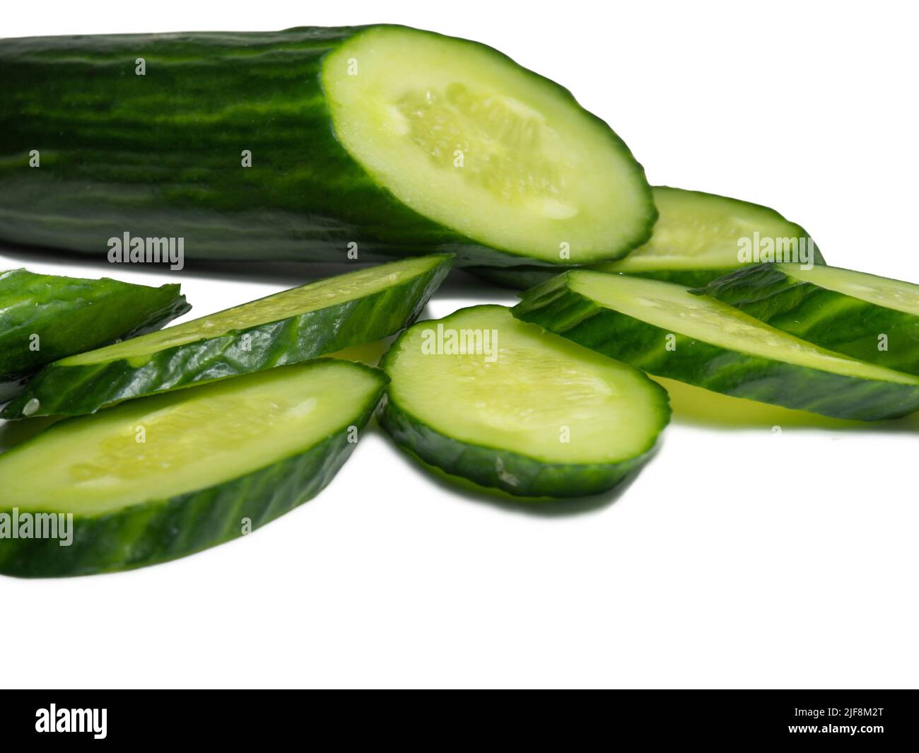 Smooth medium-sized cucumber on a white background. Cucumber slices ...