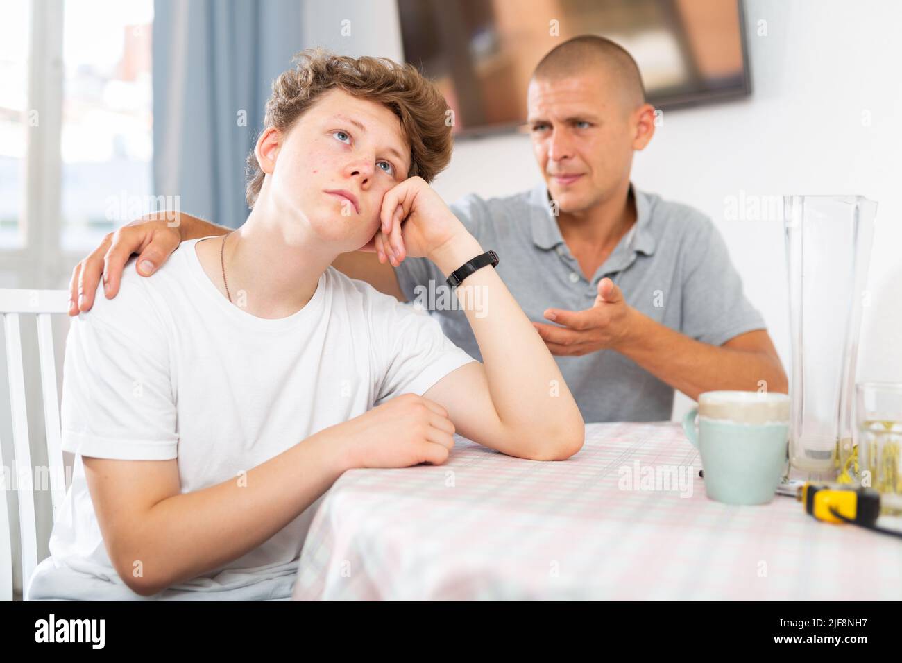 Son feeling sad and father talking to him Stock Photo - Alamy